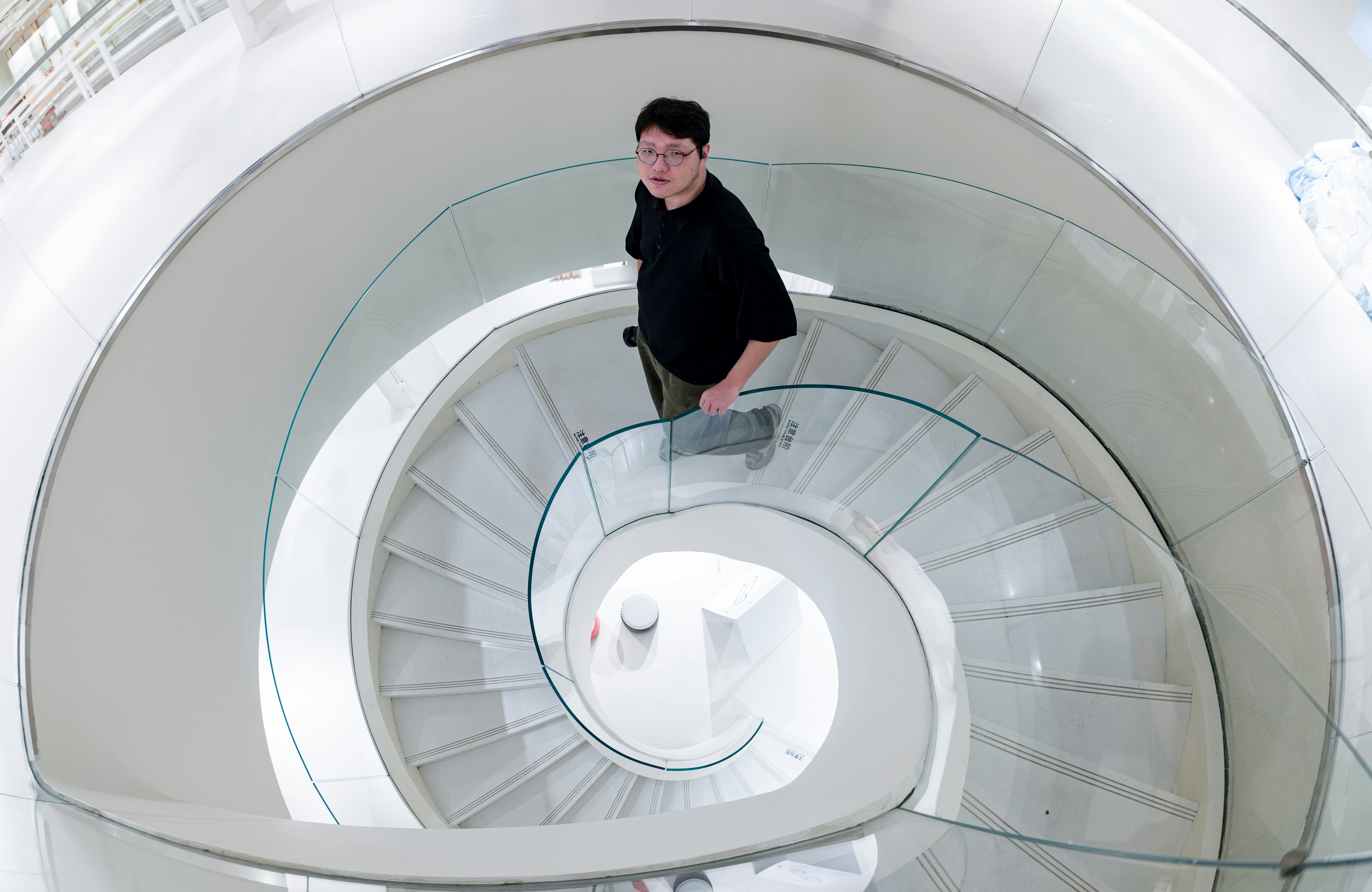 A man stands on a spiral staircase.