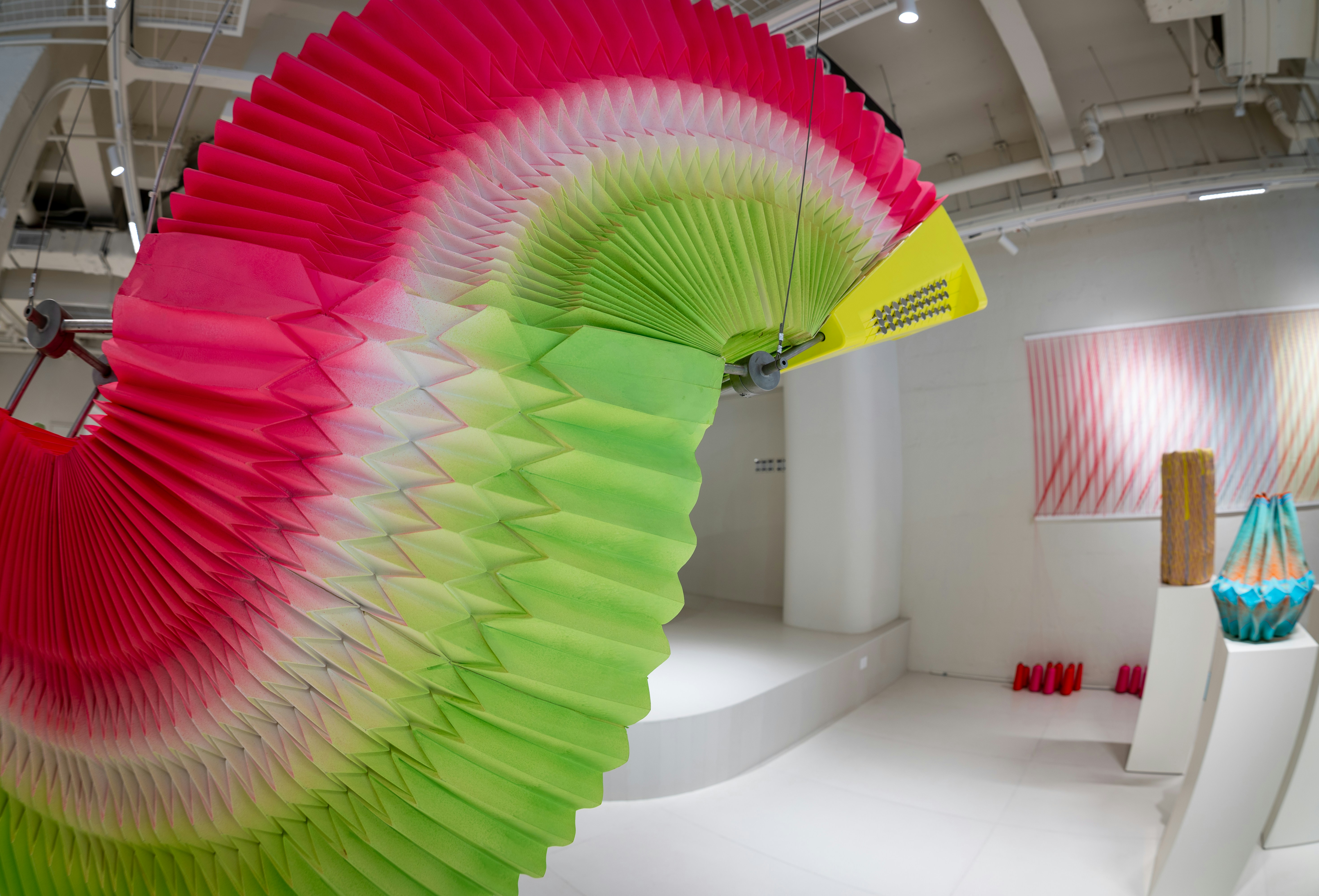 Neon Spiral: A Monumental Paper Fan Unfolding in a White Gallery