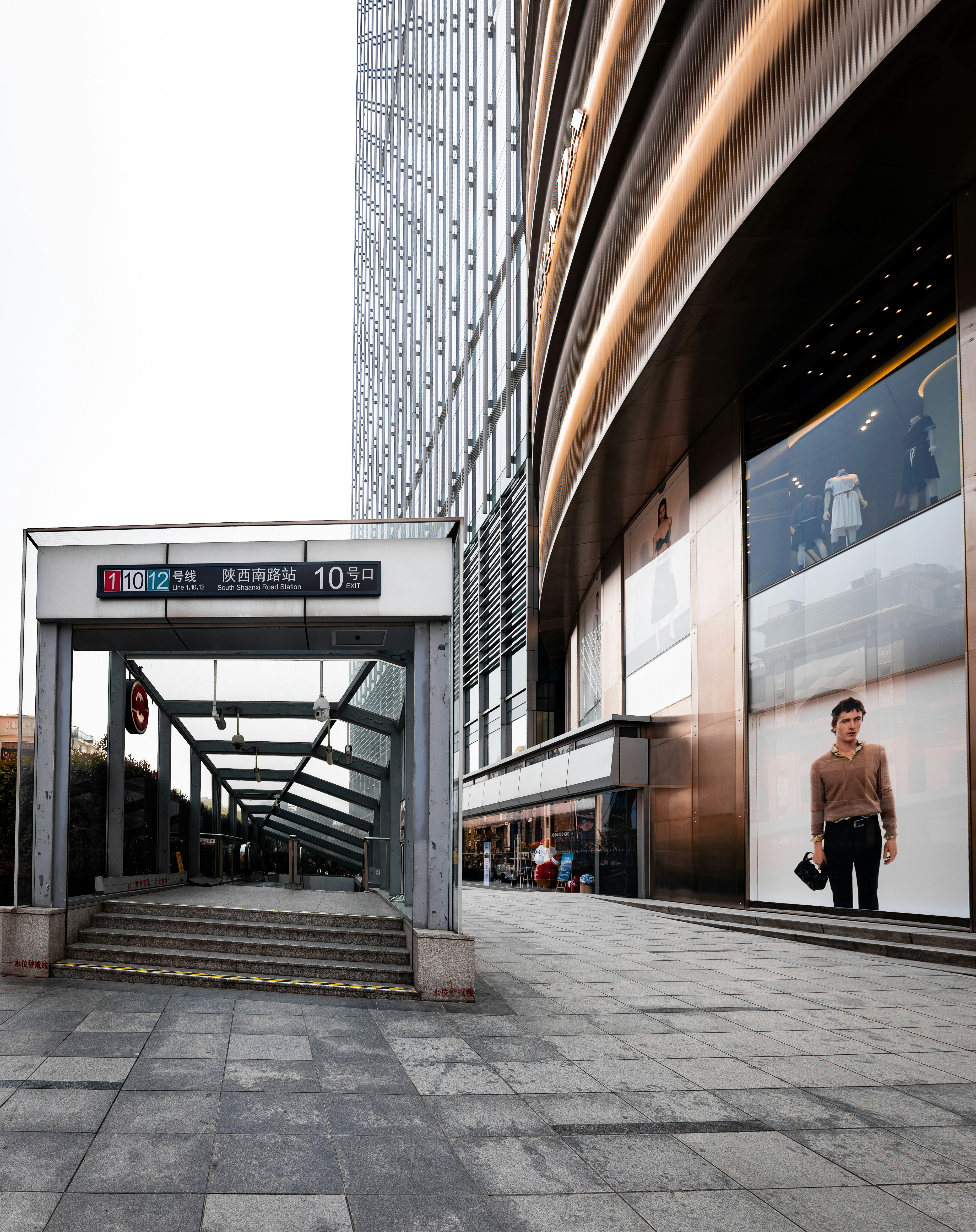 Warm-Brown Sweater Man Framed by Glass Facade in Urban Atrium