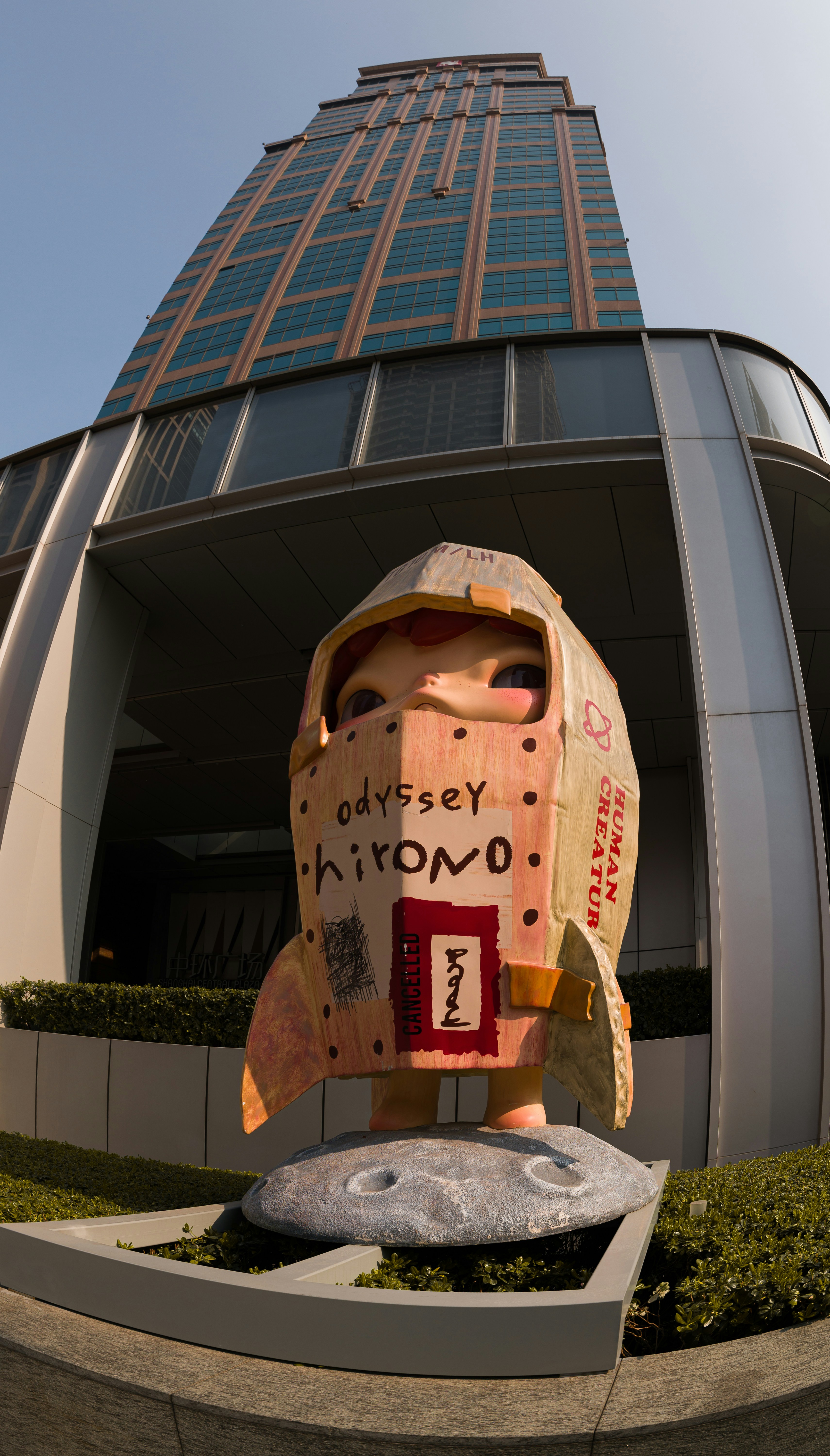 A rocket-themed statue stands before a tall building. photo – Free ...