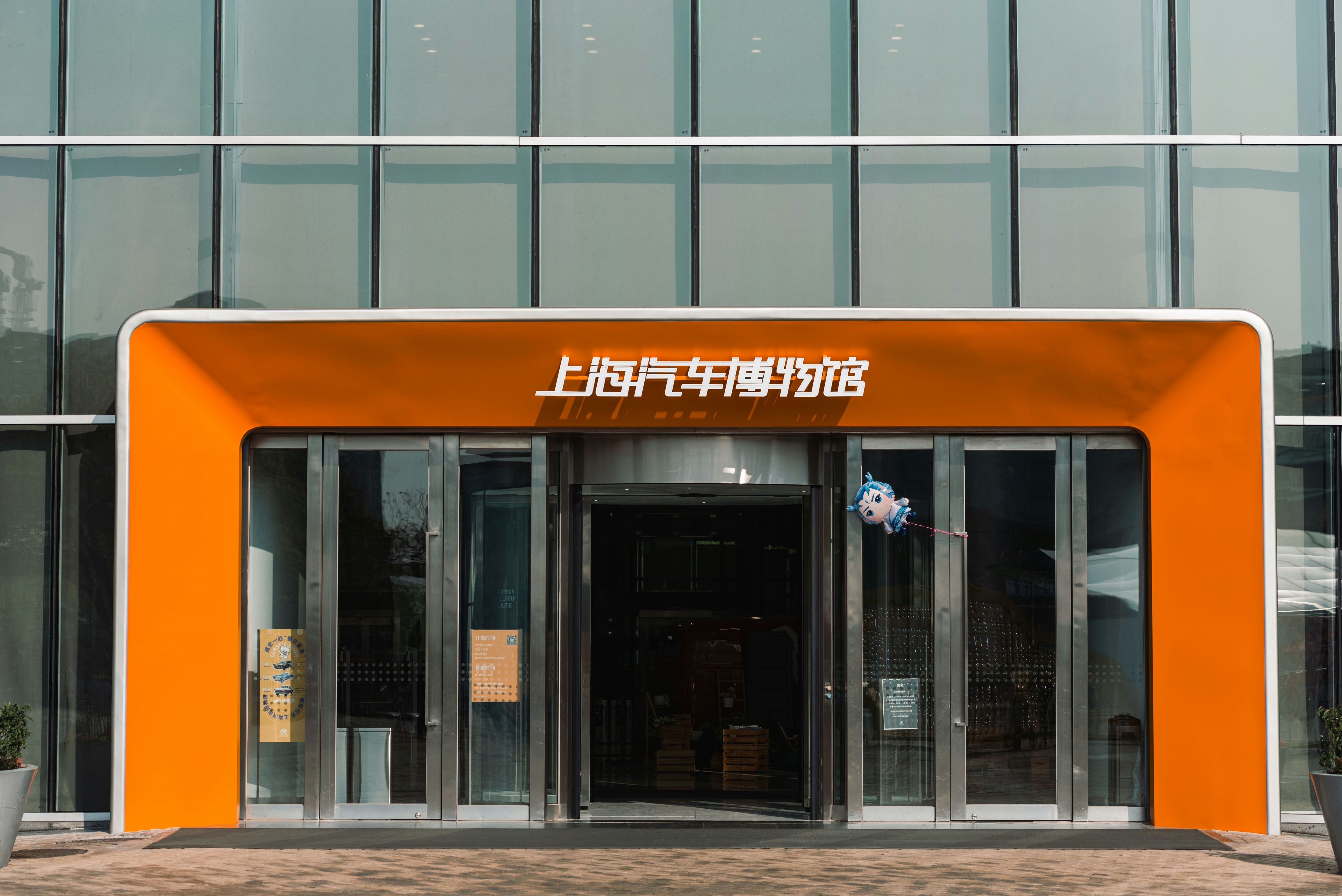 Bold orange-framed entrance to a contemporary glass building.
