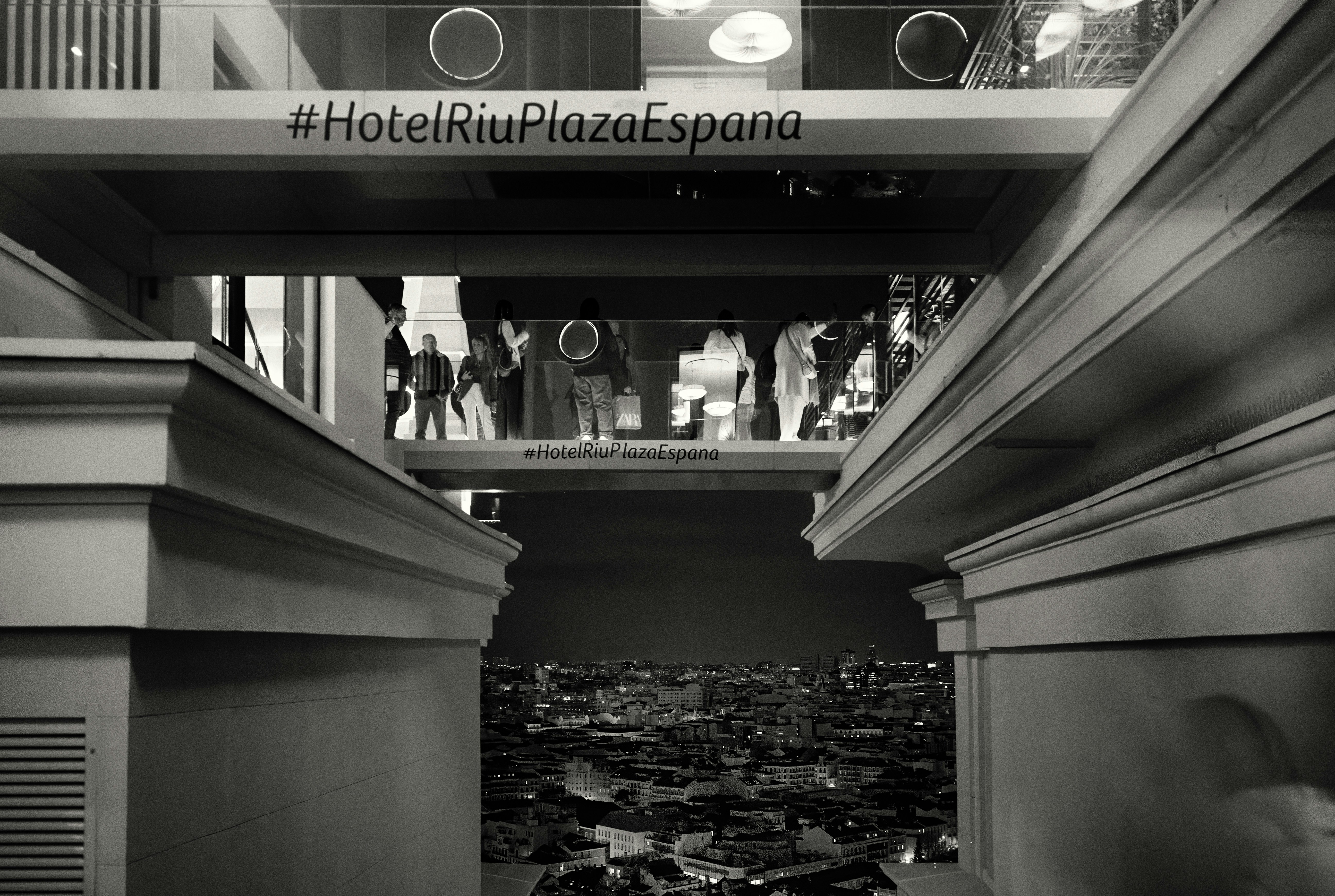 Black and white urban scene with reflective surfaces and architectural details.