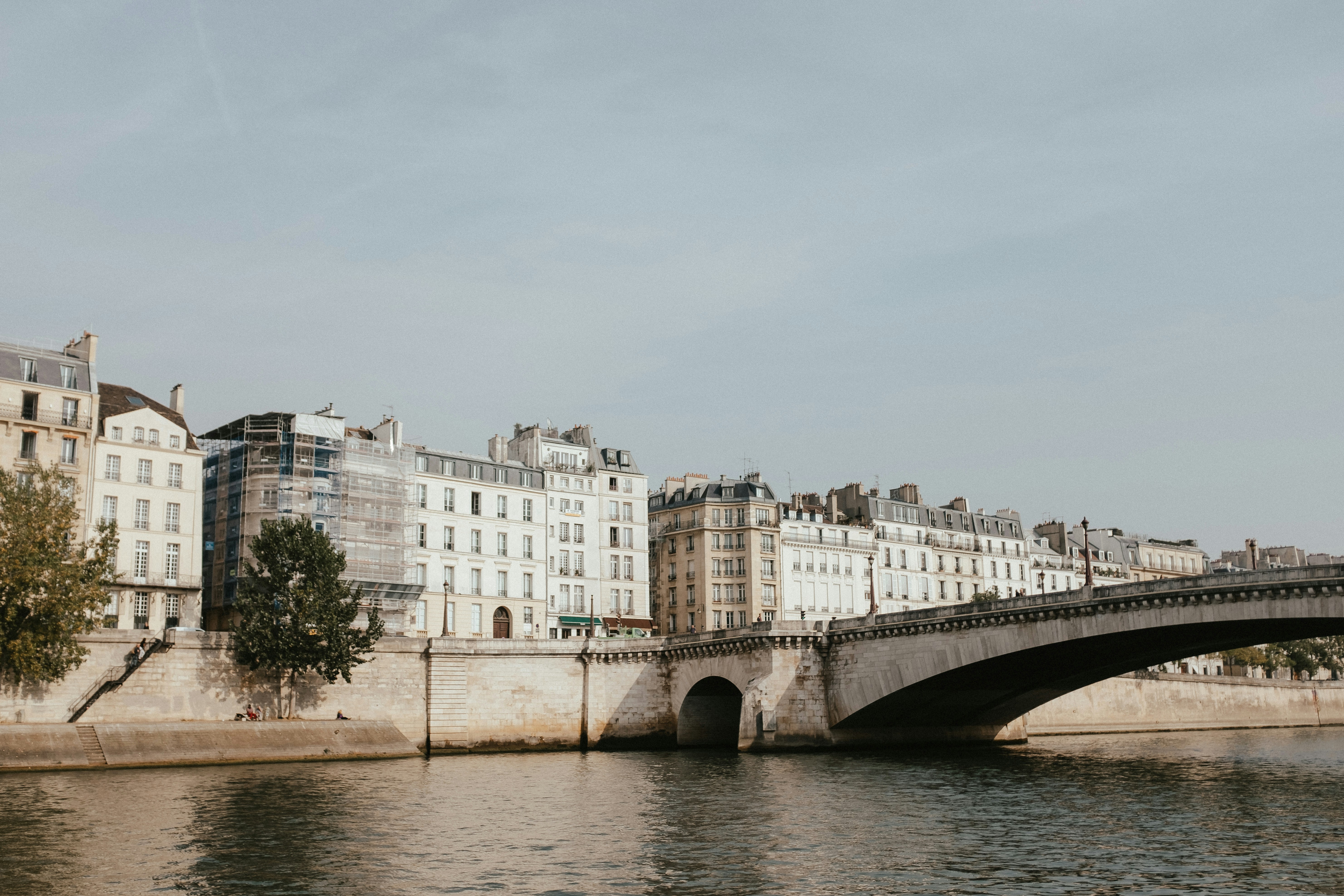 Paris buildings stand along a river with a bridge. photo – Free Paris ...