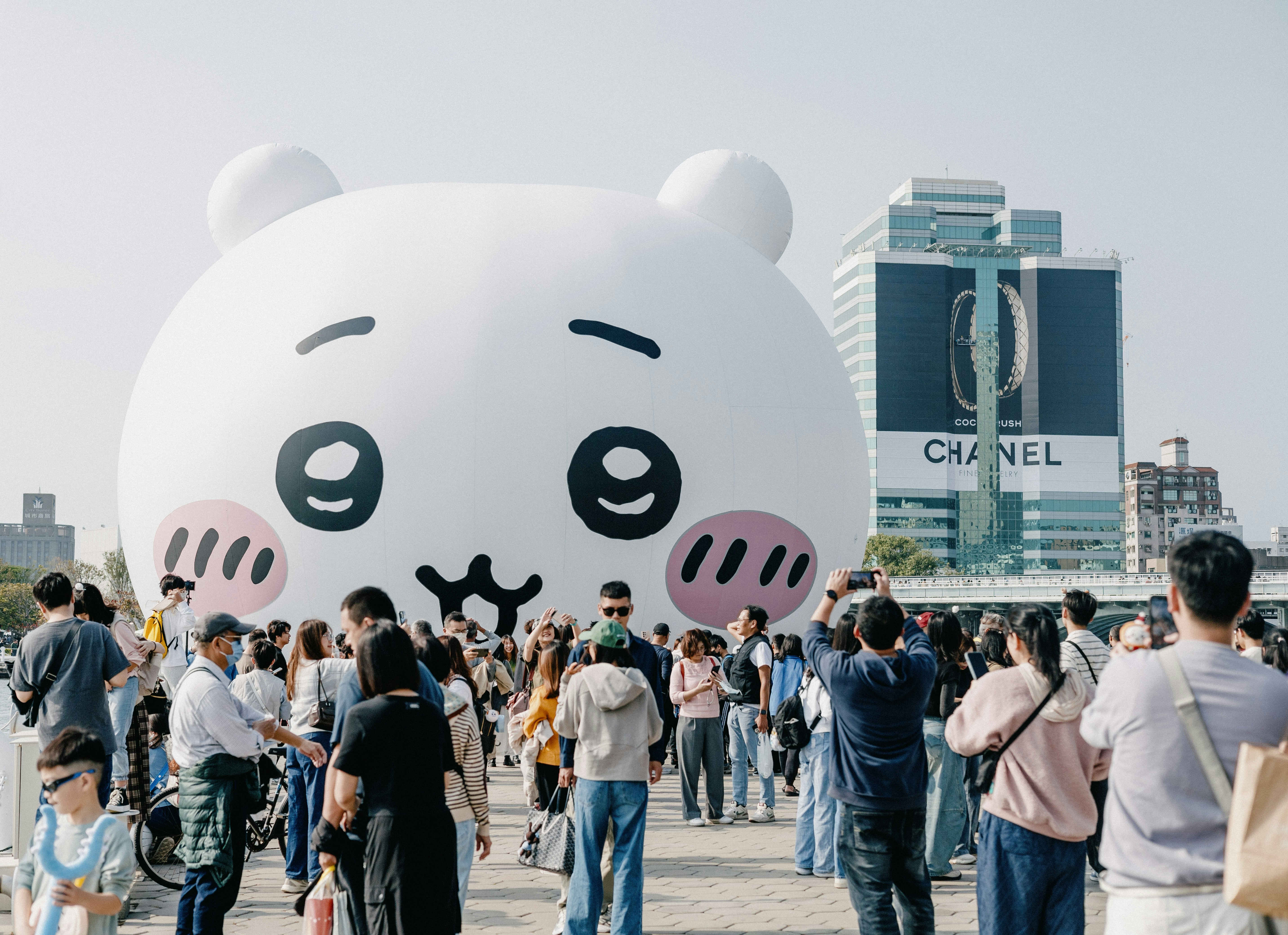 A crowd gathers around a giant inflatable character. photo – Free ...