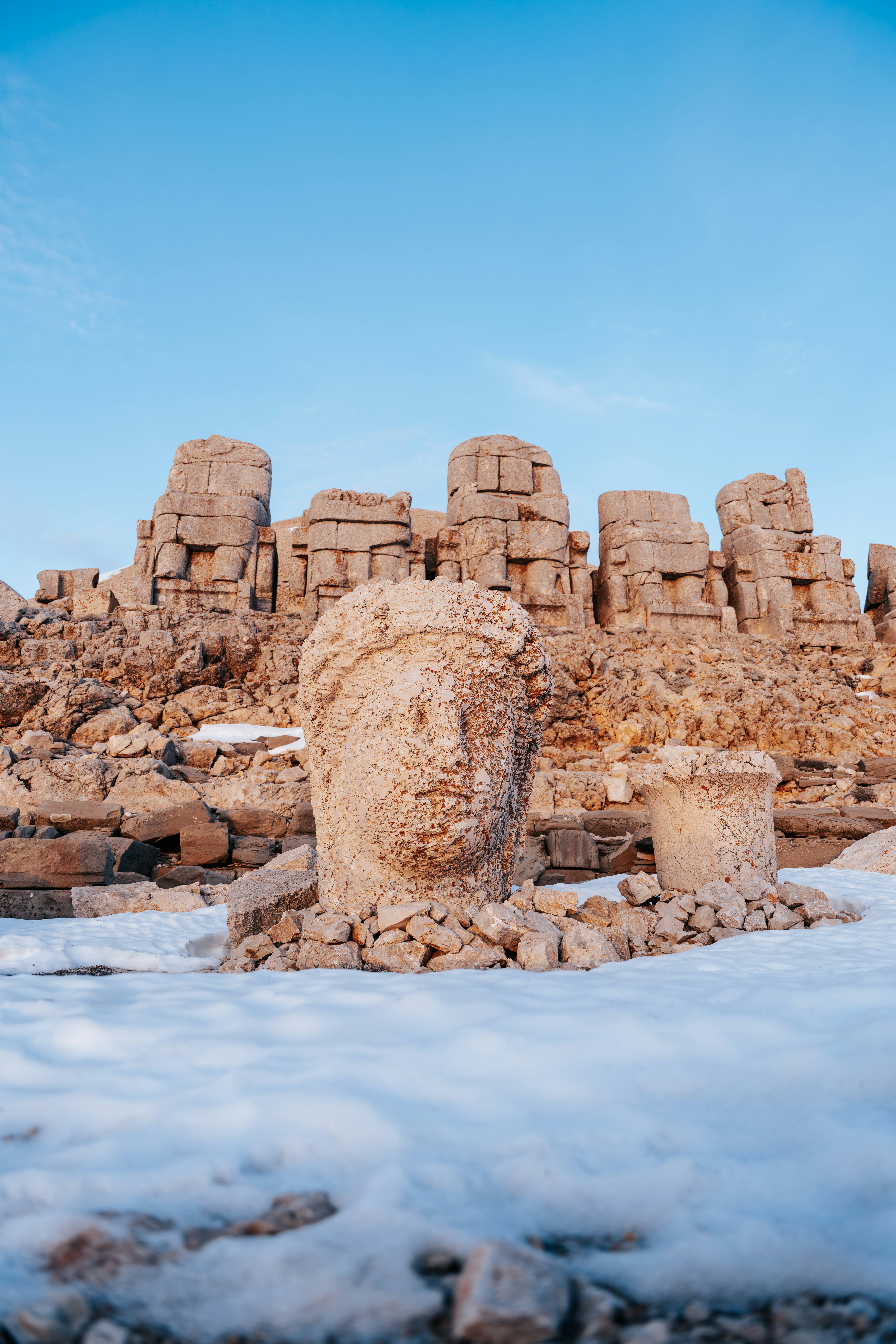 The Frozen Sentinel: A Weathered Head Amid Snow-Dusted Ruins
