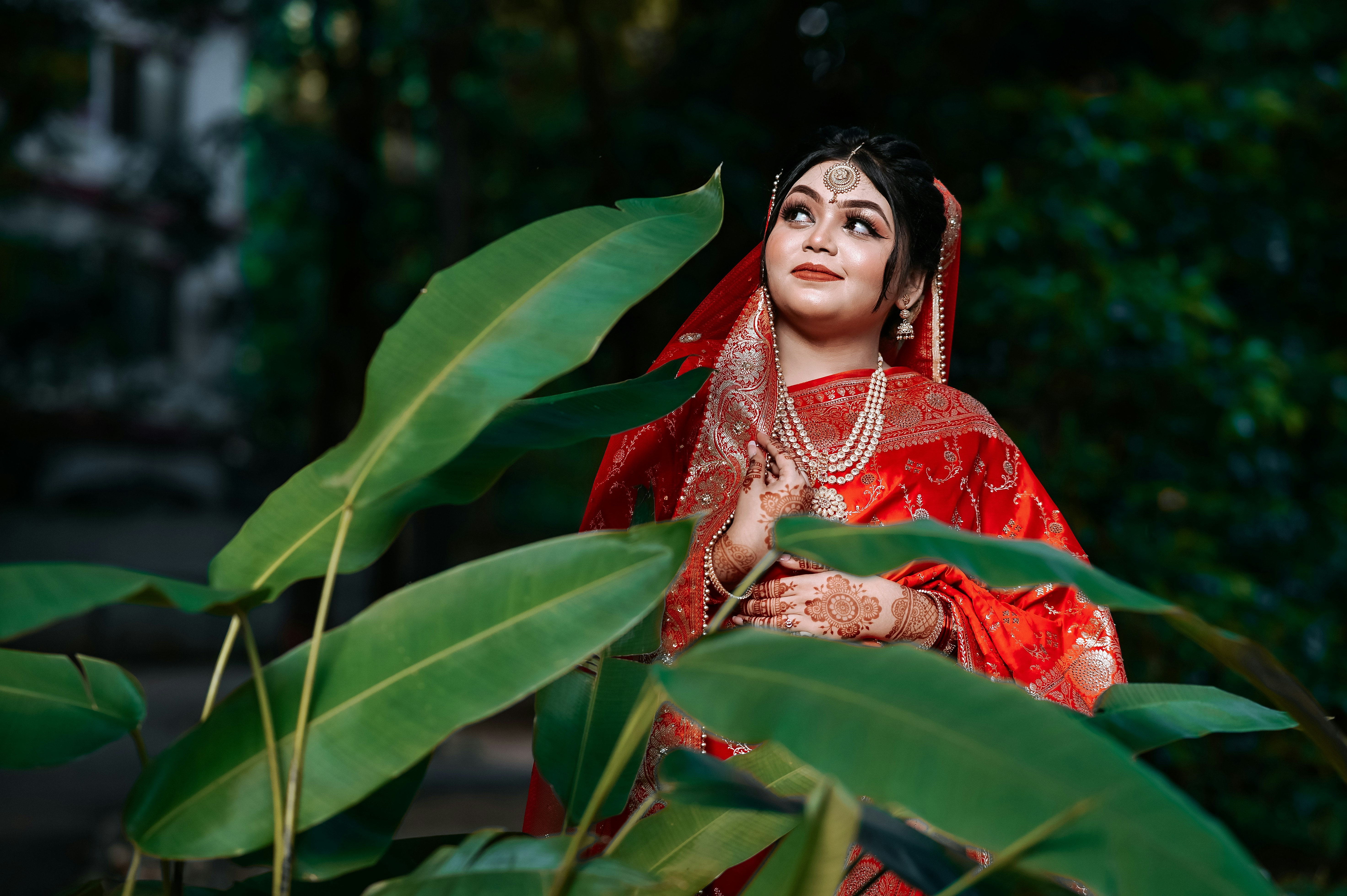 A beautiful bride poses among lush green foliage. photo – Free Woman ...