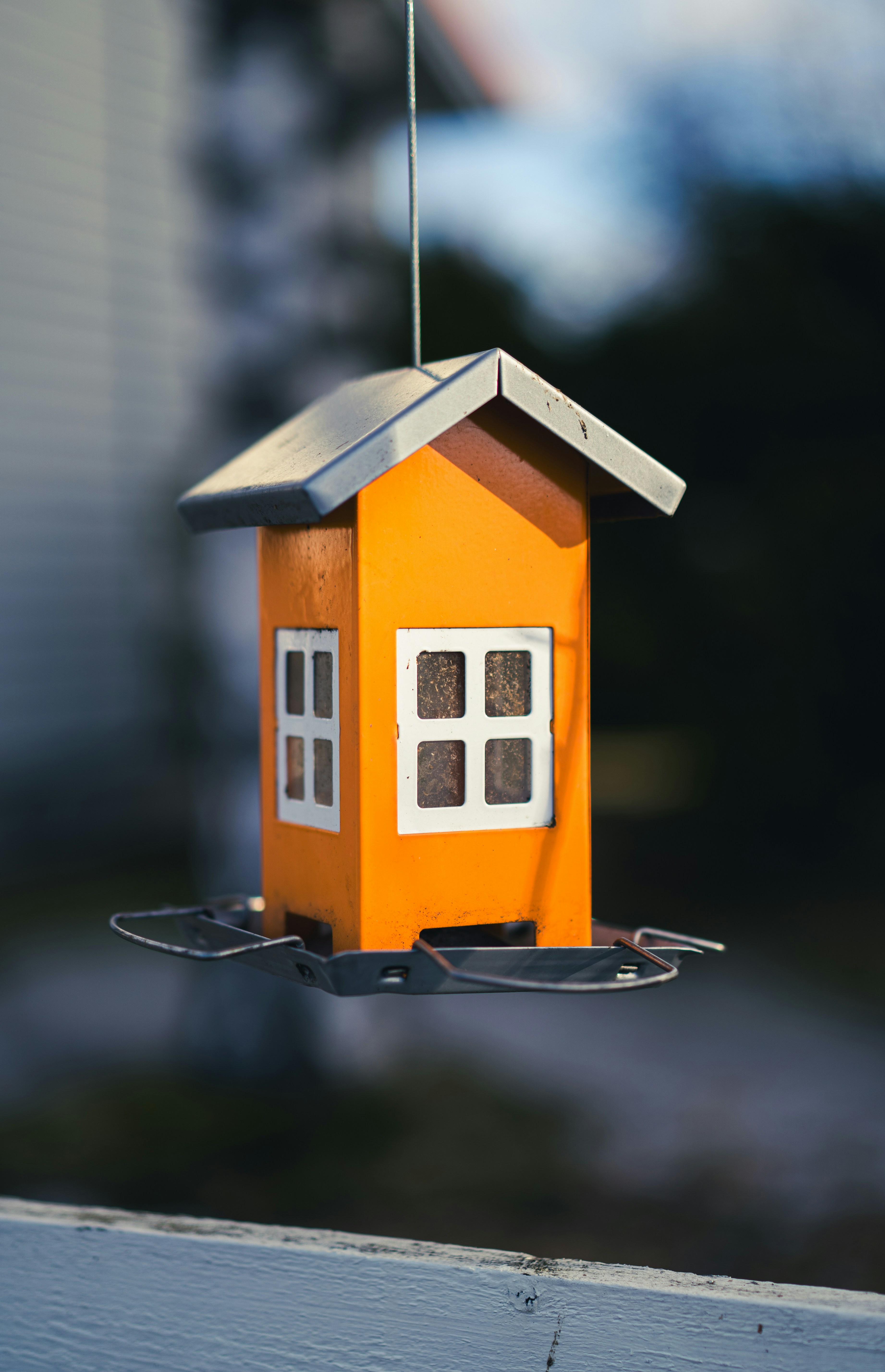 A colorful birdhouse is hanging from a wire. photo – Free House Image ...