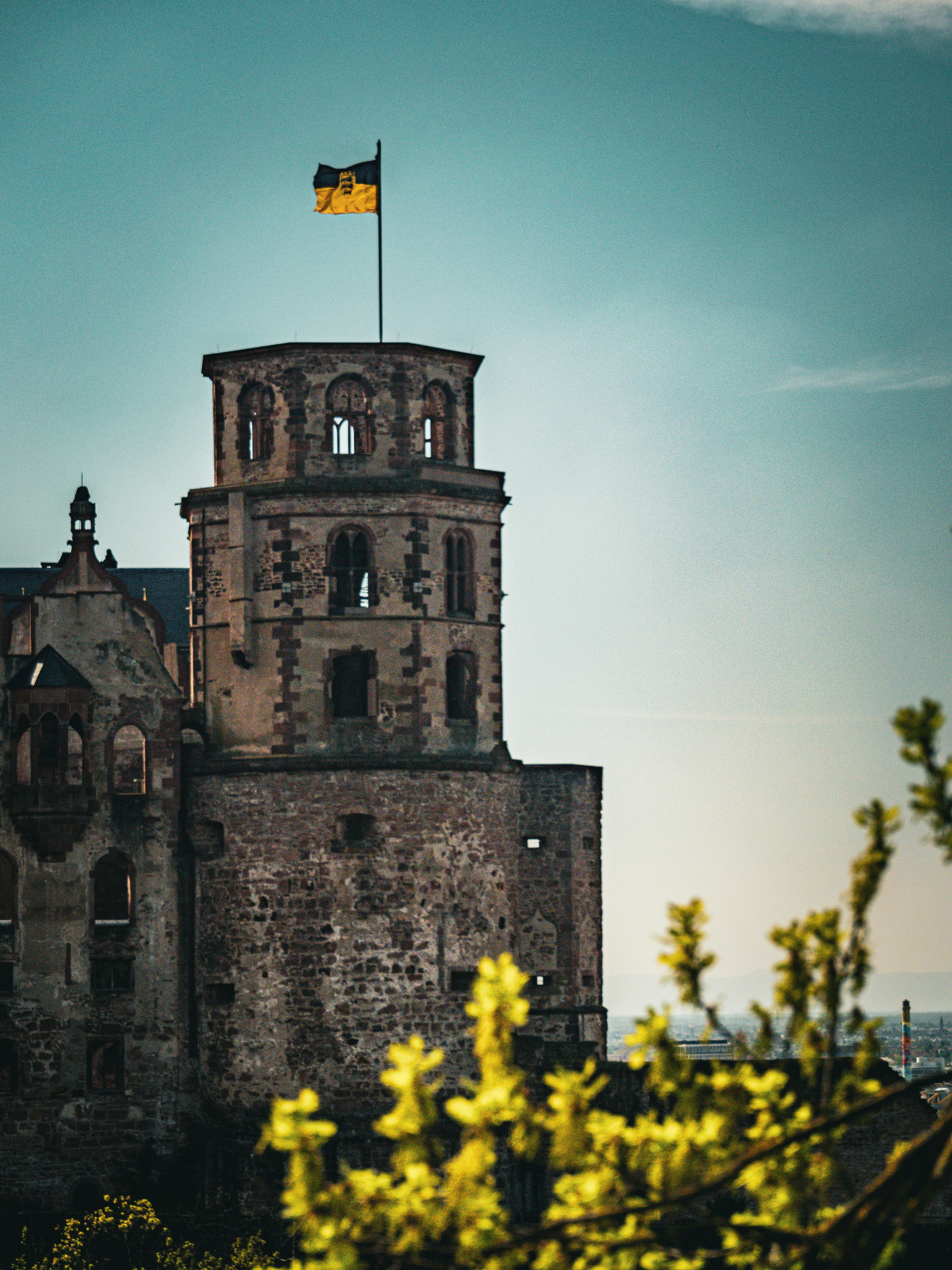 Flag Over a Weathered Keep Against a Calm Azure Sky