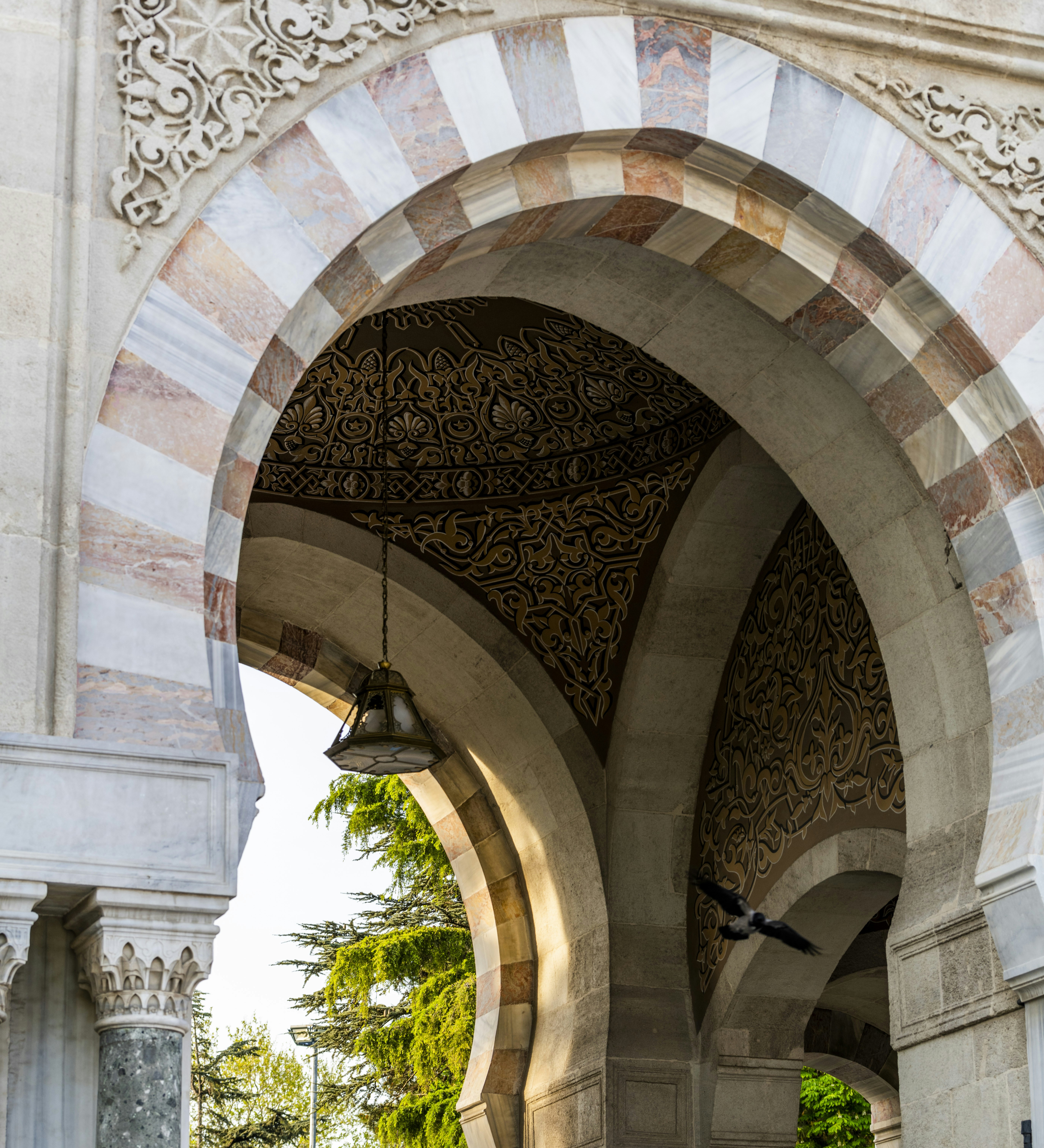 Striped Archway of Quiet Detail: Lantern Beneath Carved Vaults