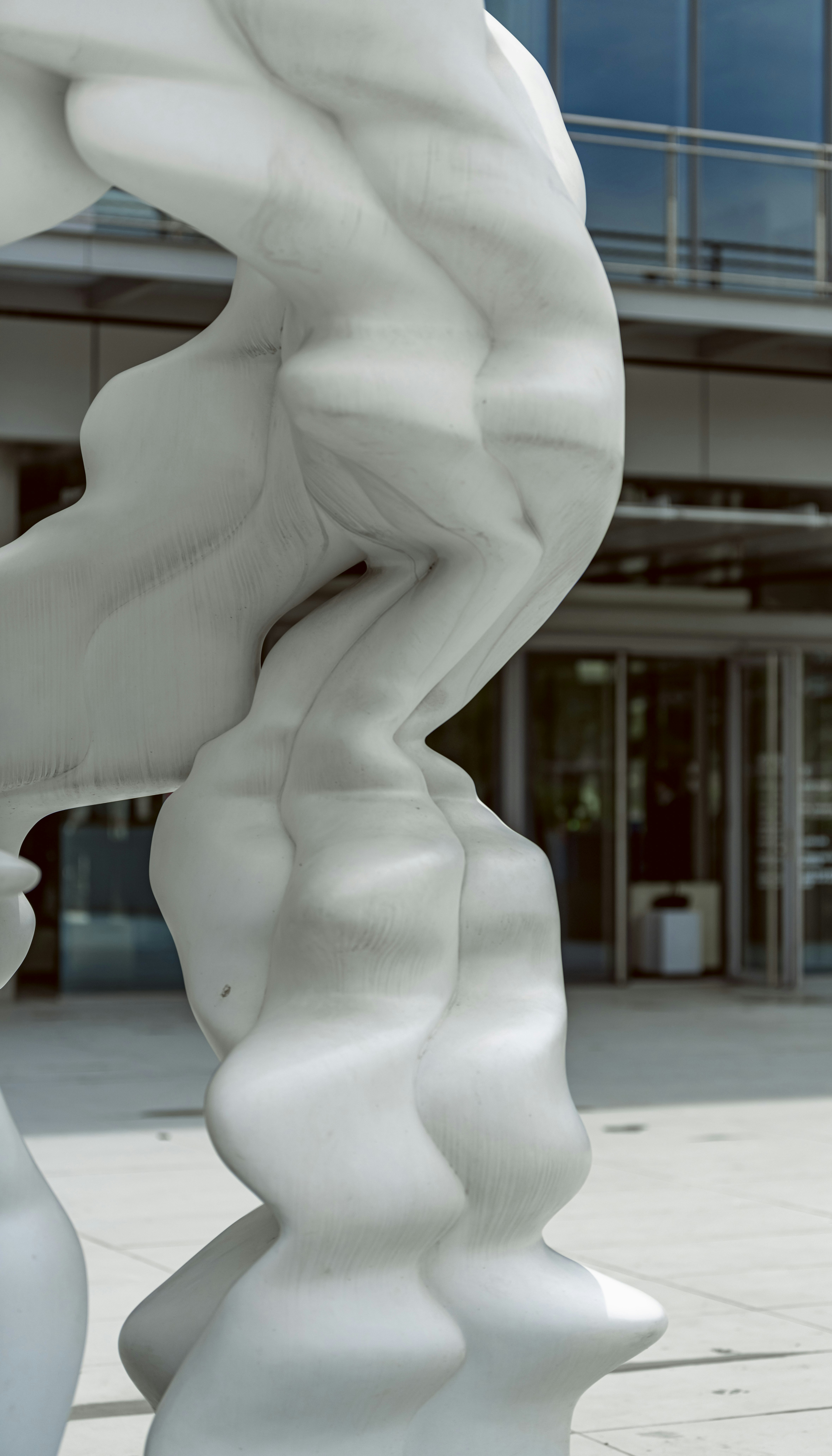 White Contours in the City: An Abstract Marble Sculpture by the Glass Atrium