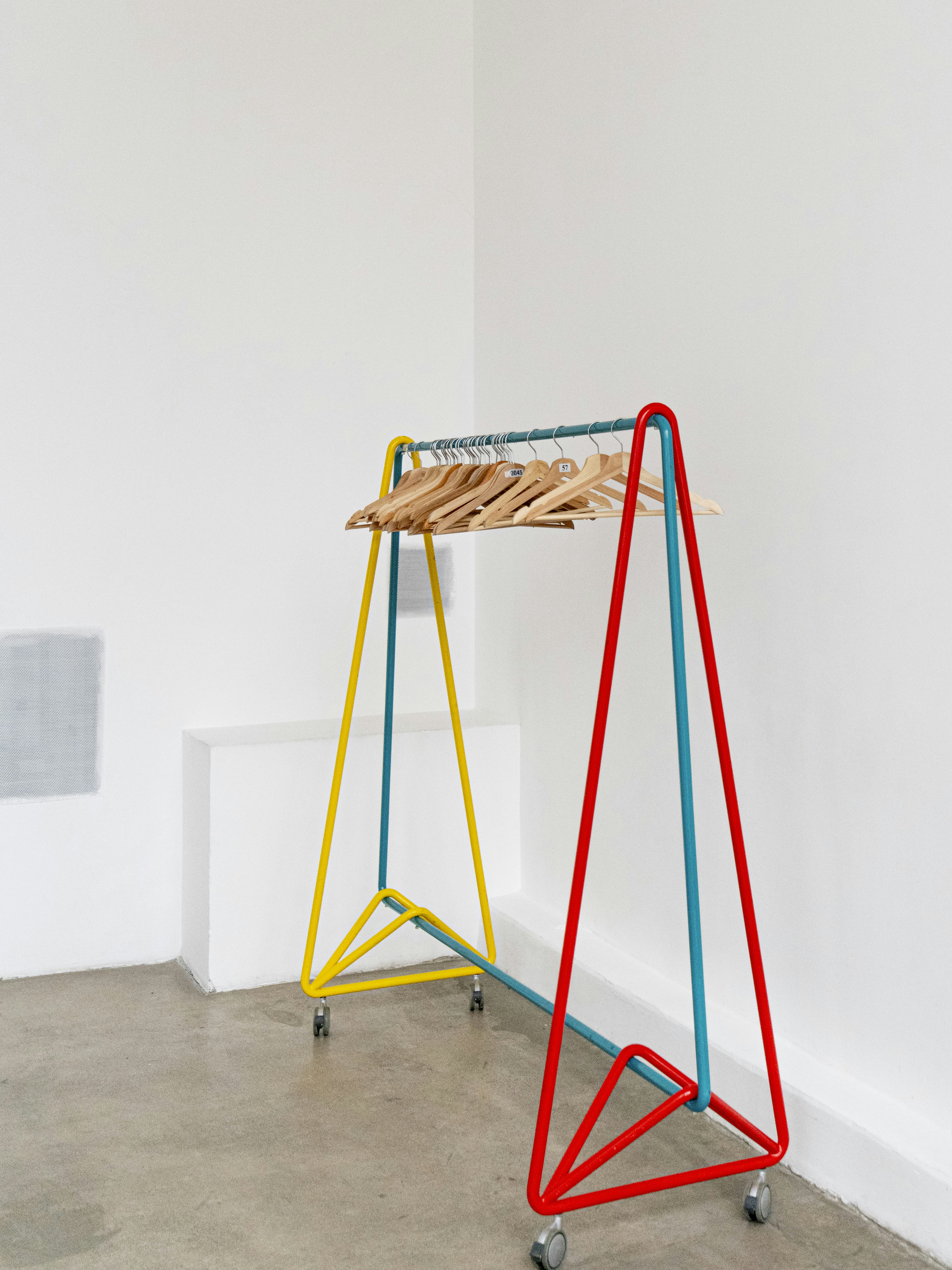 Colorful garment rack in a sparse white room