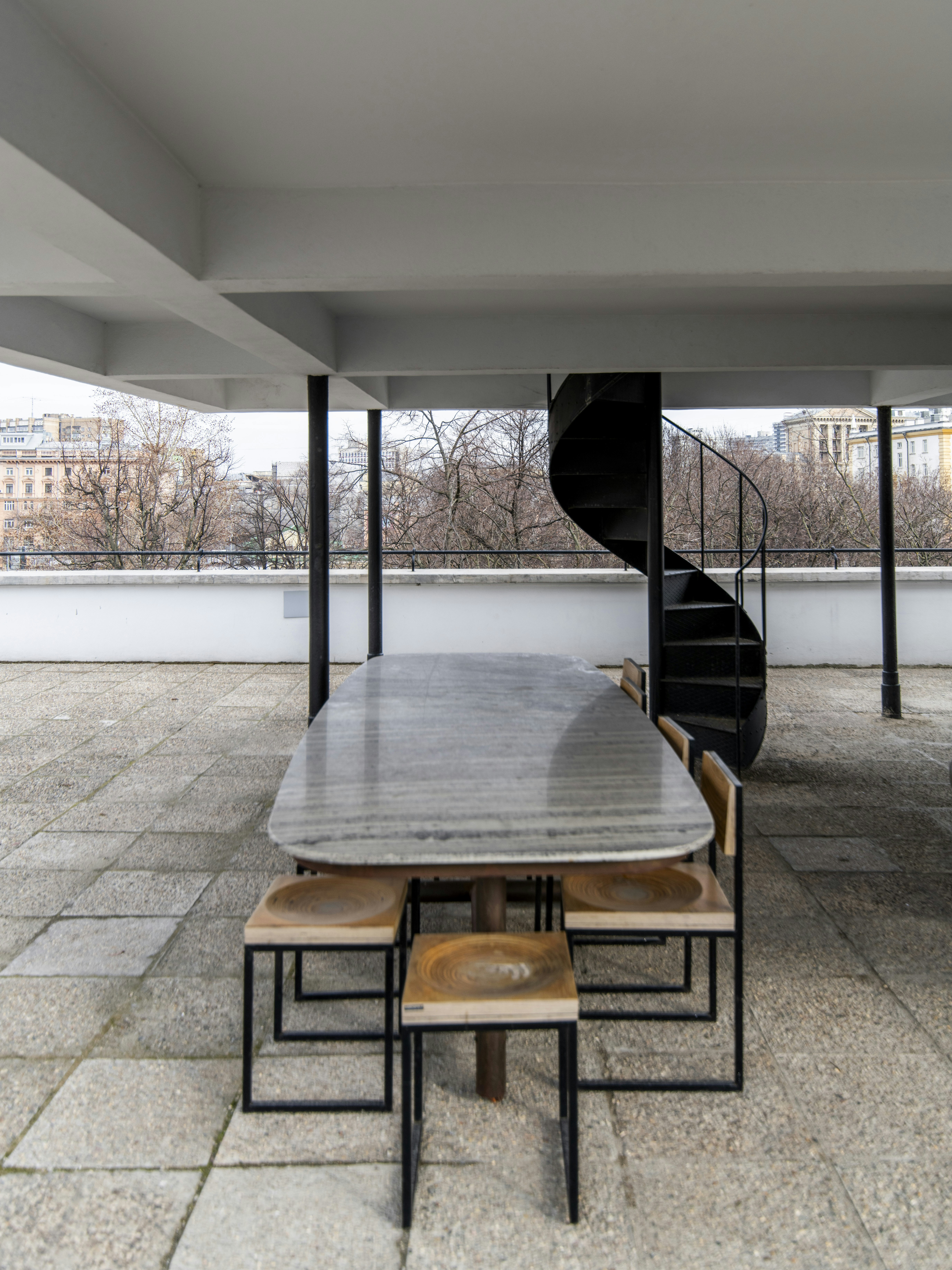 Concrete Terrace and Spiral Staircase: A Quiet Moment Under the Overhang
