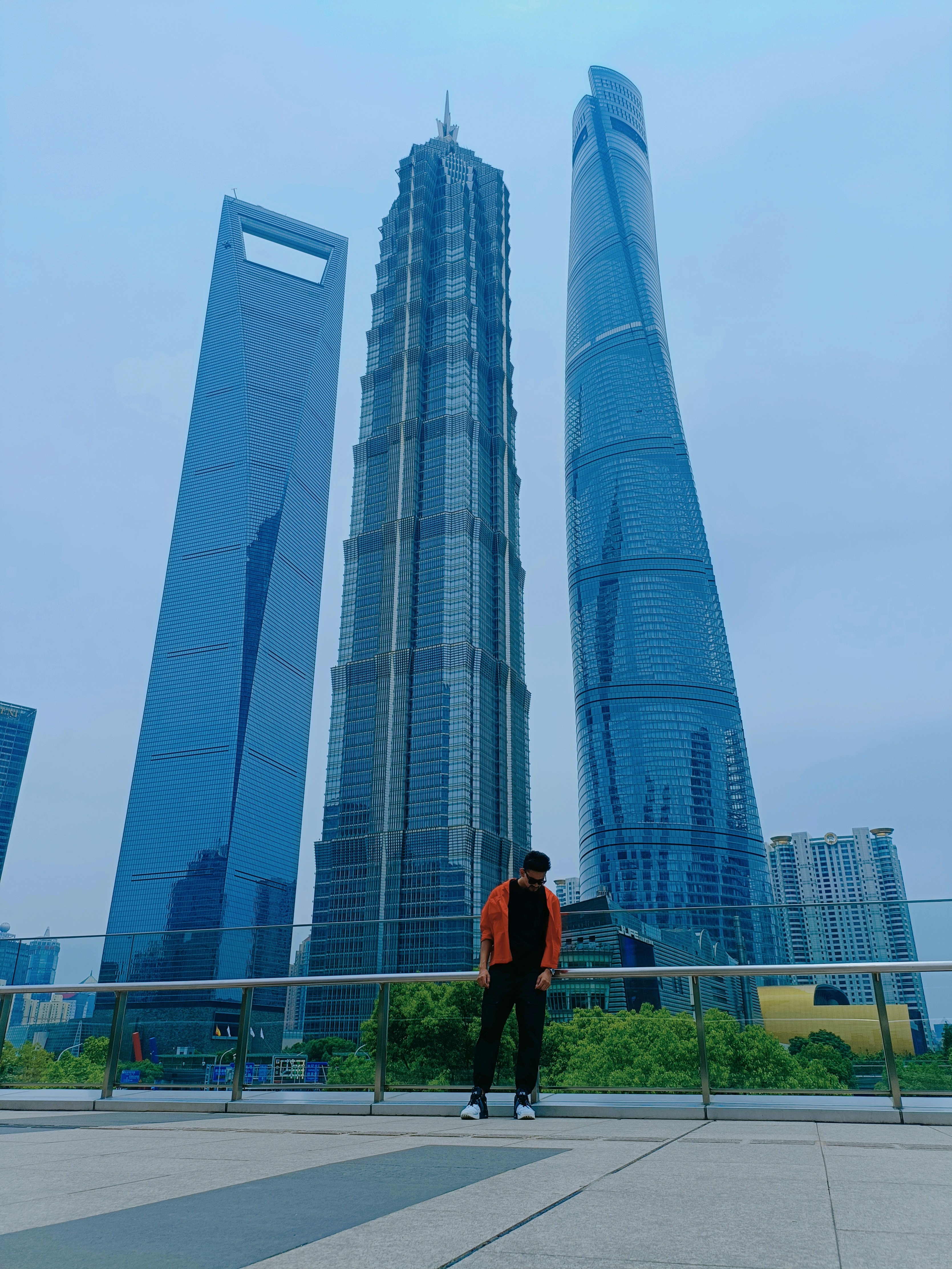 Man poses in front of shanghai skyscrapers. photo – Free Building Image ...