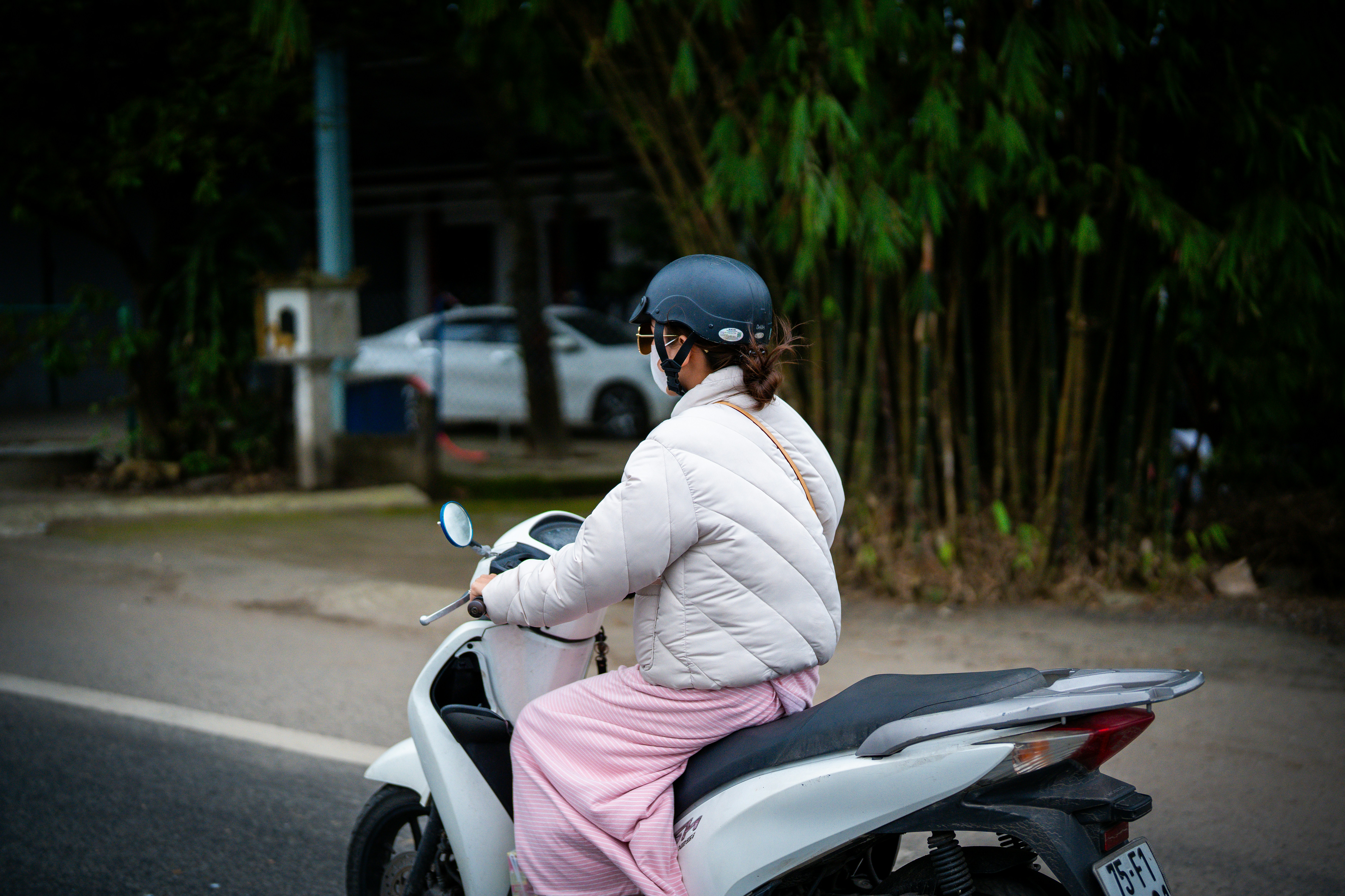 A woman rides a scooter down a road. photo – Free Car Image on Unsplash