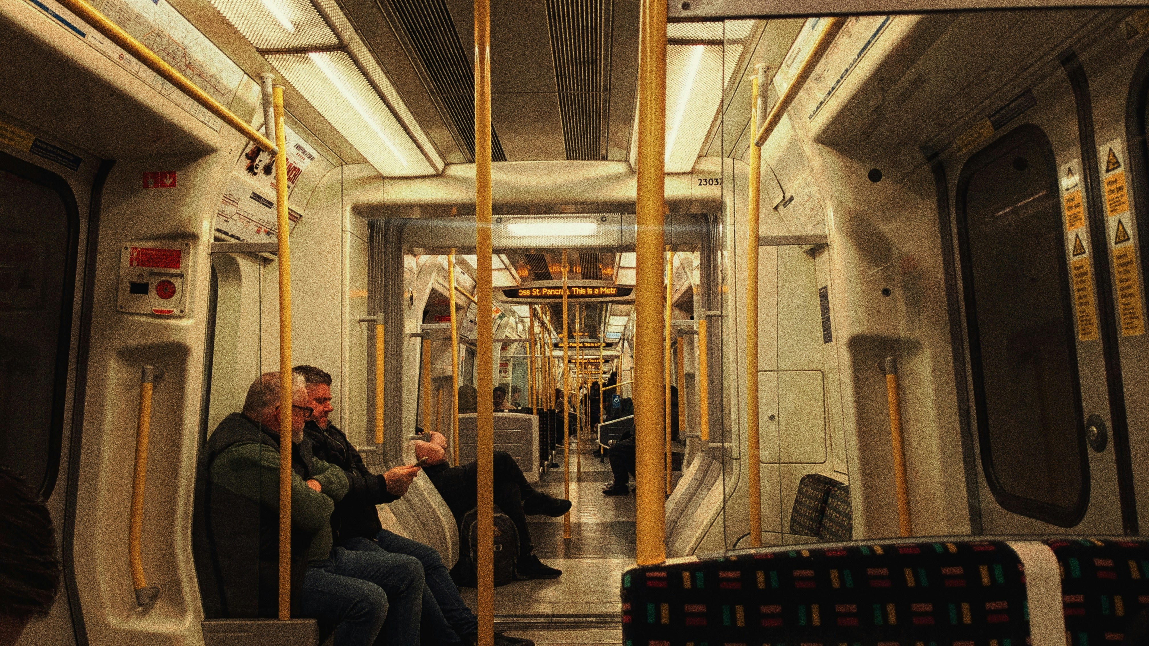 Passengers sit inside a modern train car.