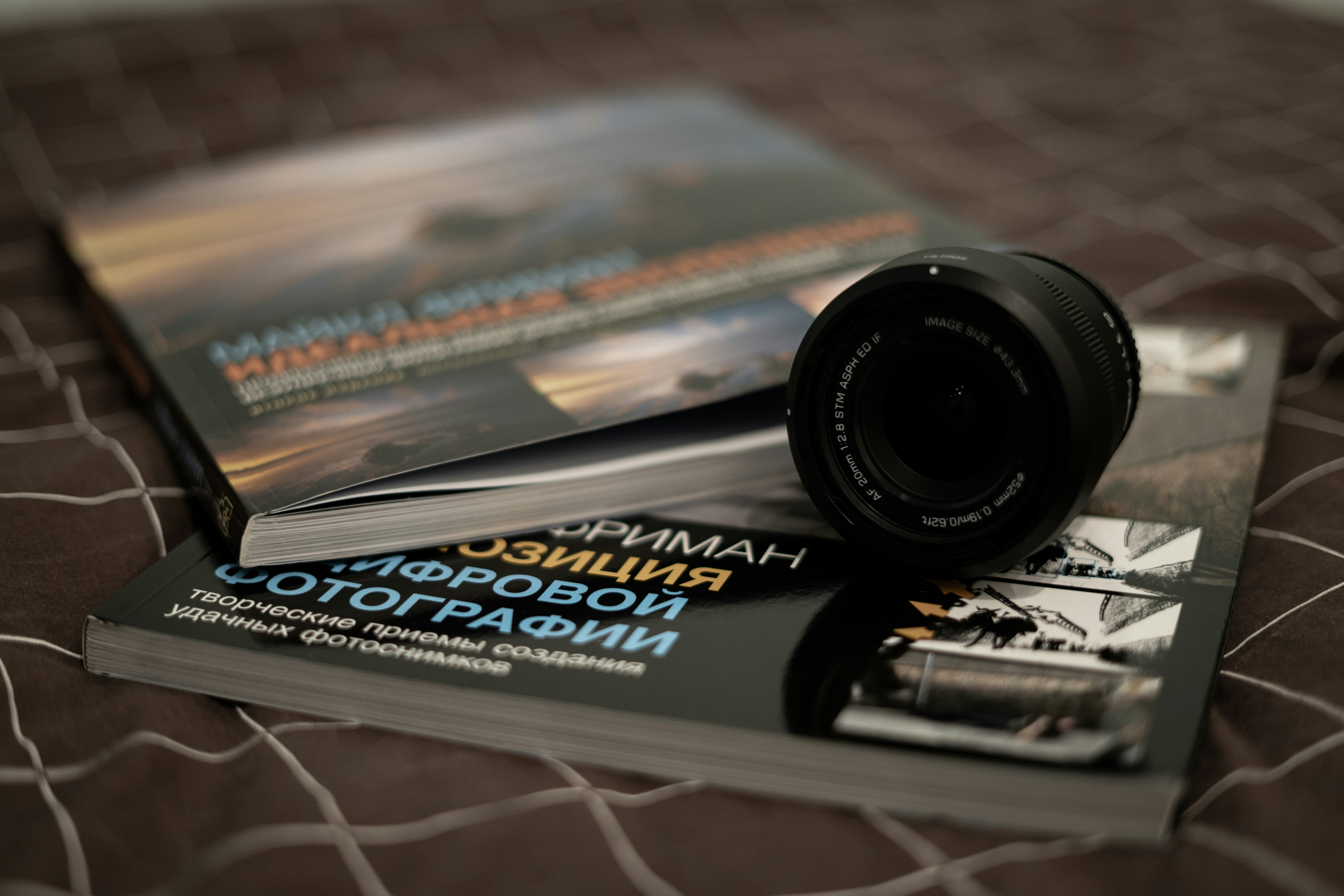 Midnight Gloss: A Prime Lens Resting on Russian Photo Volumes
