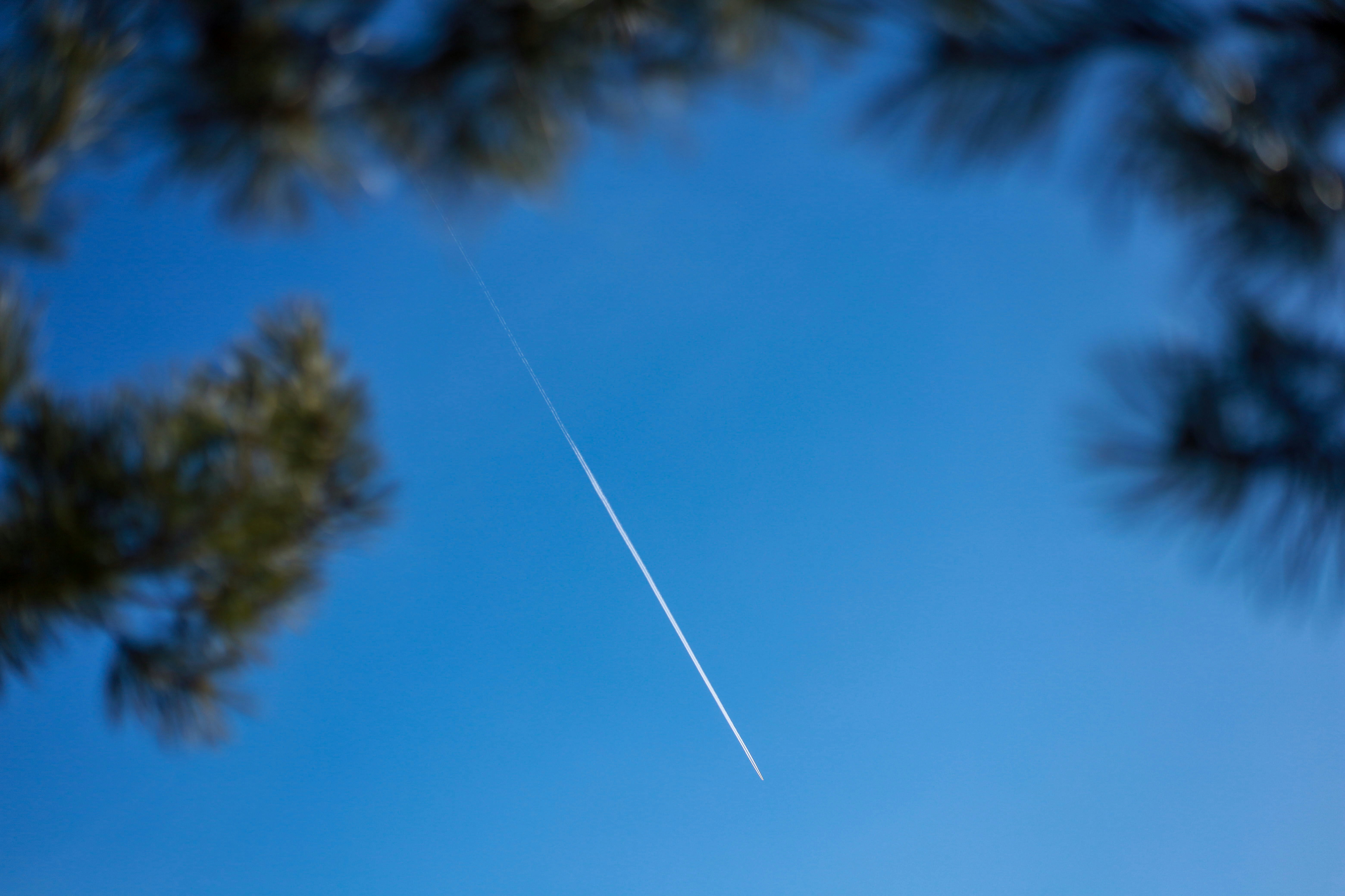 An airplane contrail streaks across a bright blue sky. photo – Free Cat Image on Unsplash