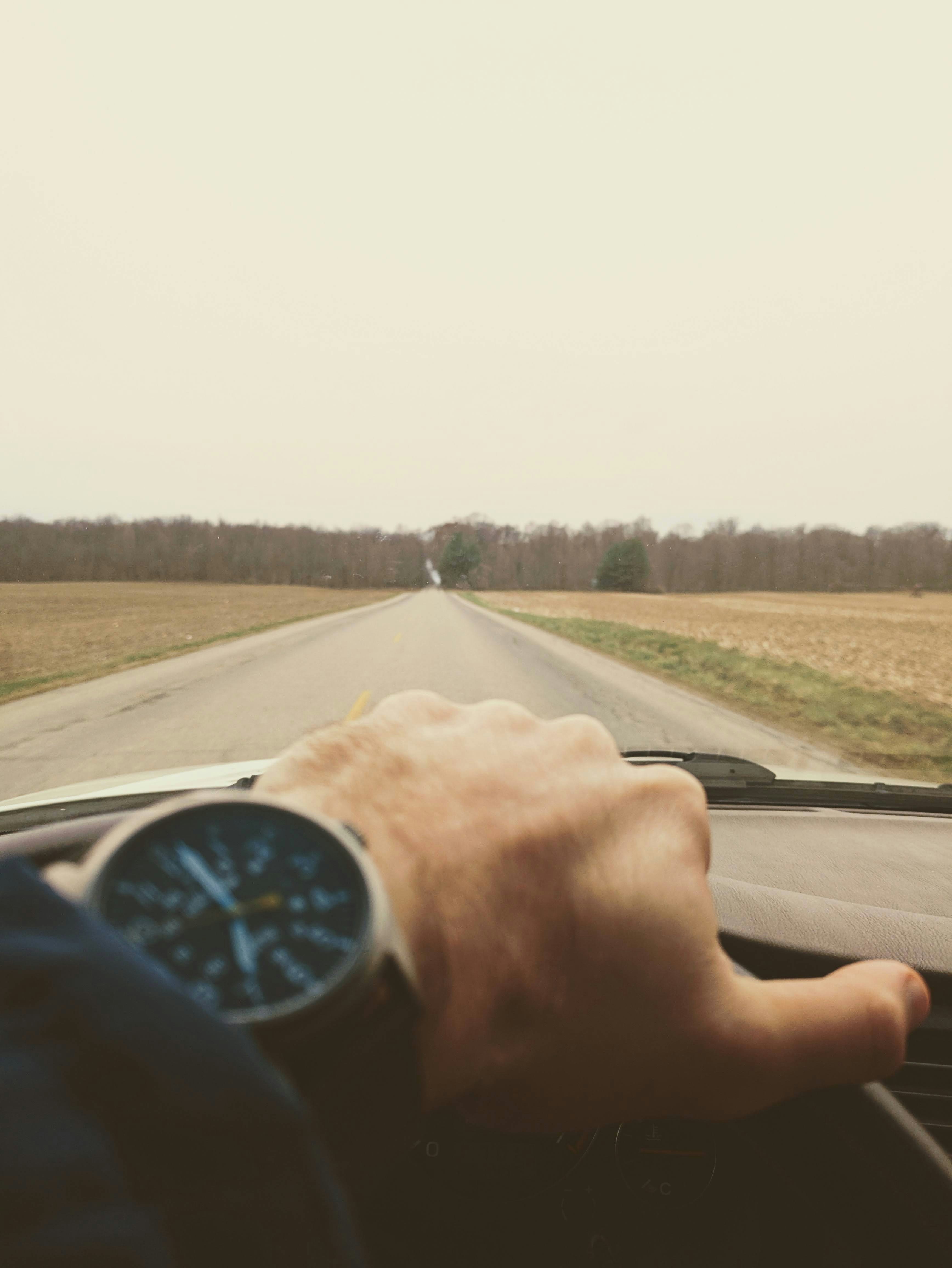Driving down a long, open country road. photo – Free Man Image on Unsplash