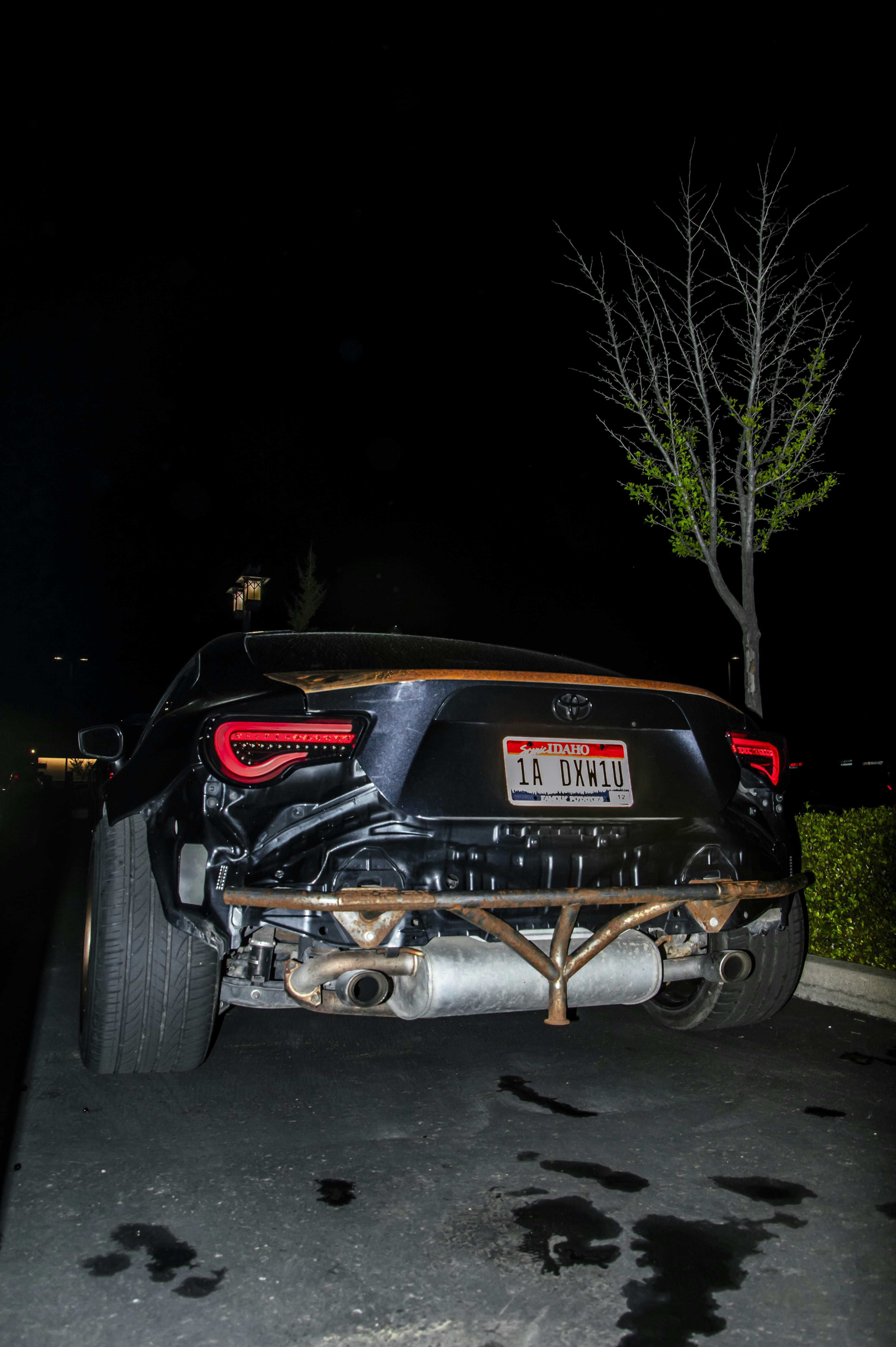 Midnight Rear-Impact: The Damaged Black Sports Coupe in a Quiet Parking Lot
