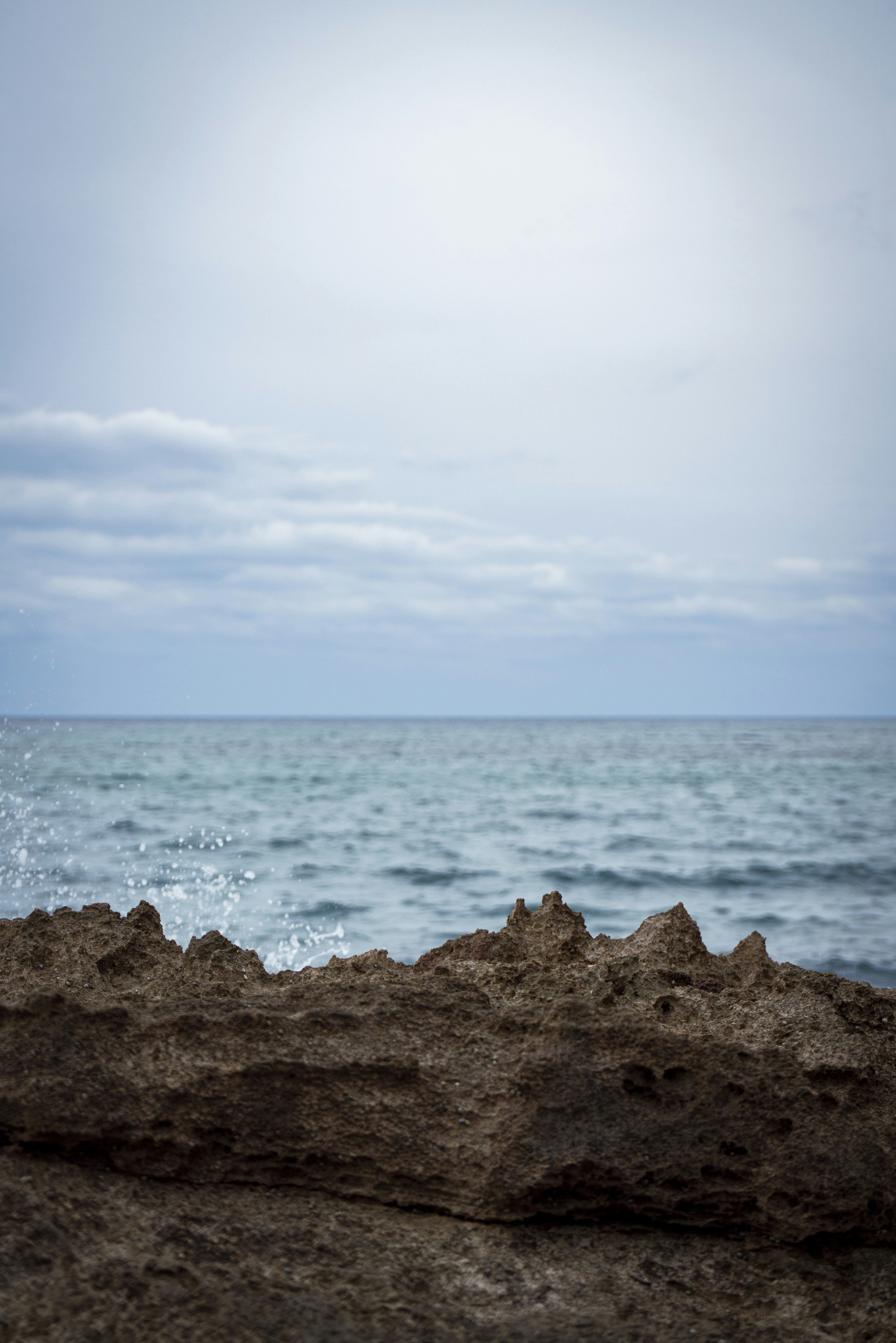 Rocky shore meets the ocean under a cloudy sky. photo – Free Beach ...