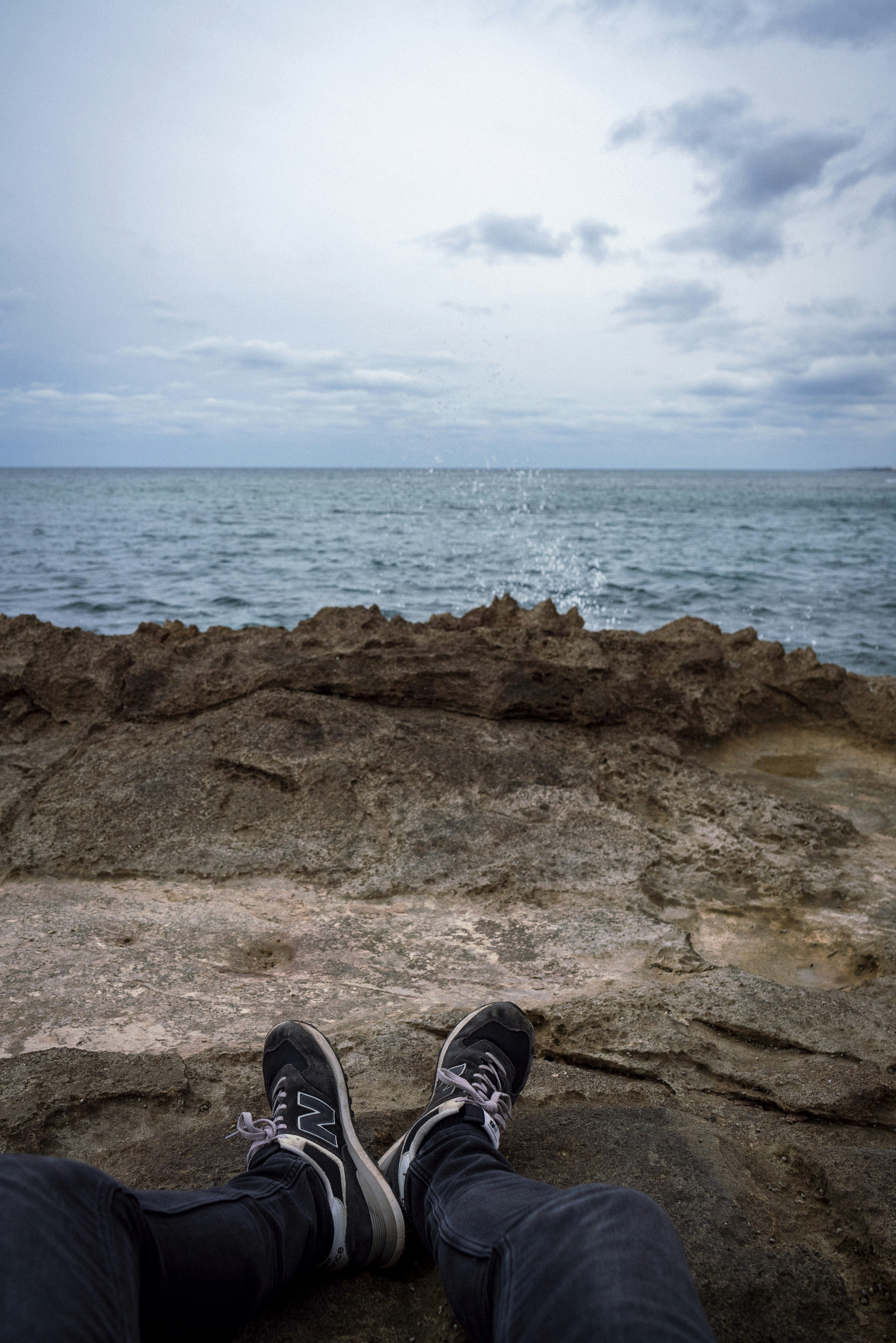 Feet rest on rocks, gazing at the ocean. photo – Free Beach Image on ...