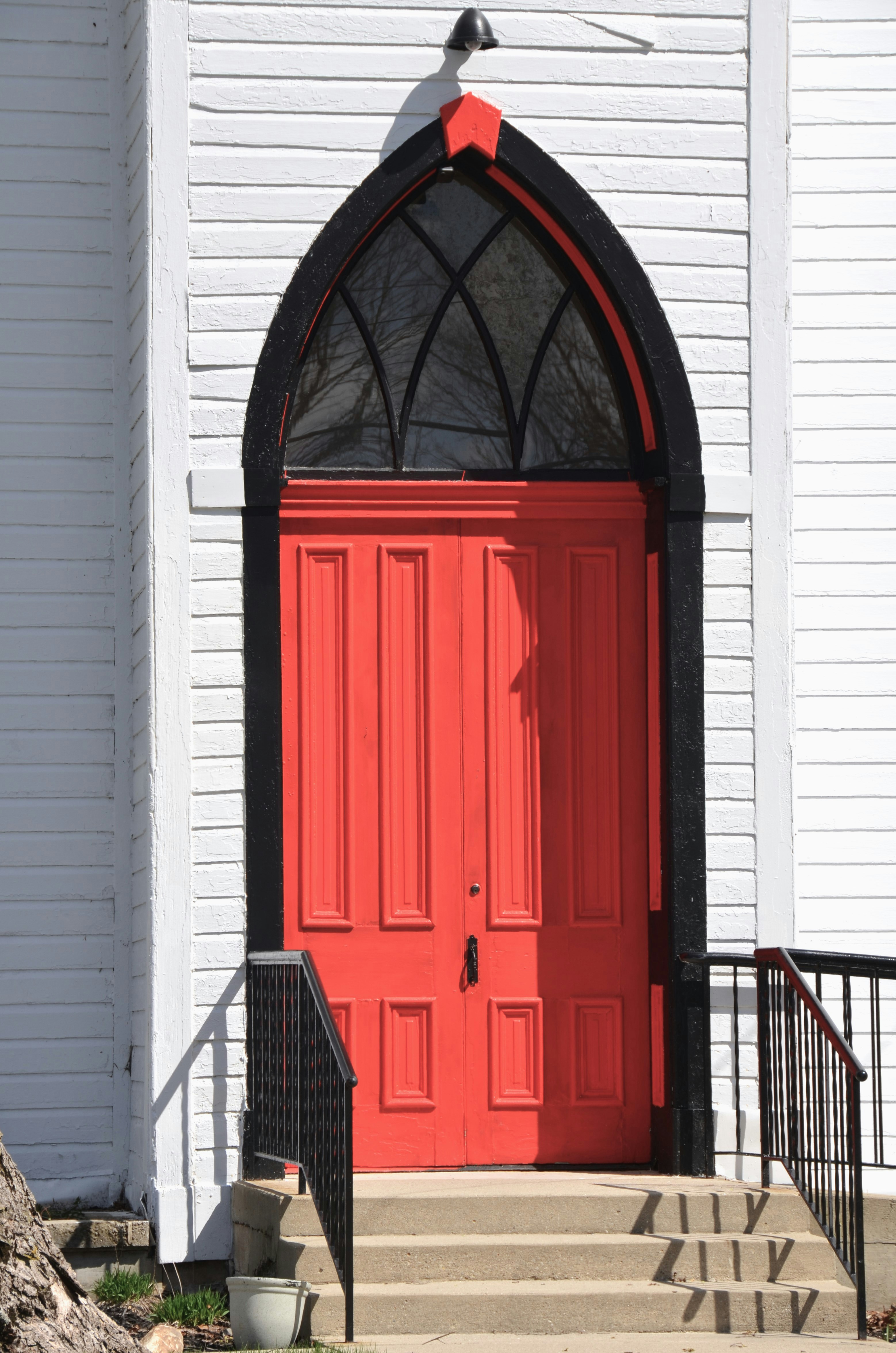 Vibrant Entryway: Gothic Arch and Crimson Door