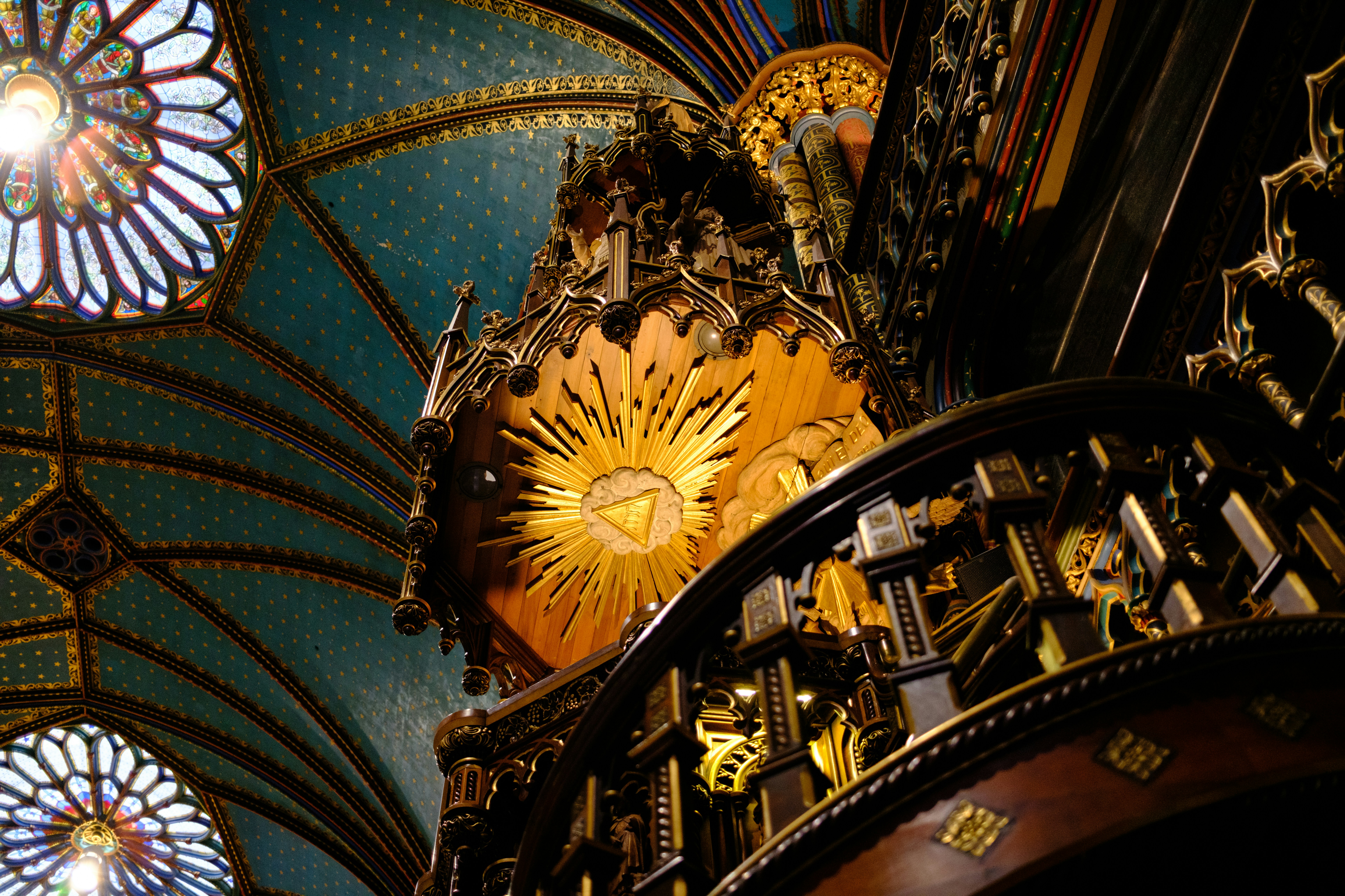 Ornate church interior with a vibrant sunburst design and intricate stained glass windows.