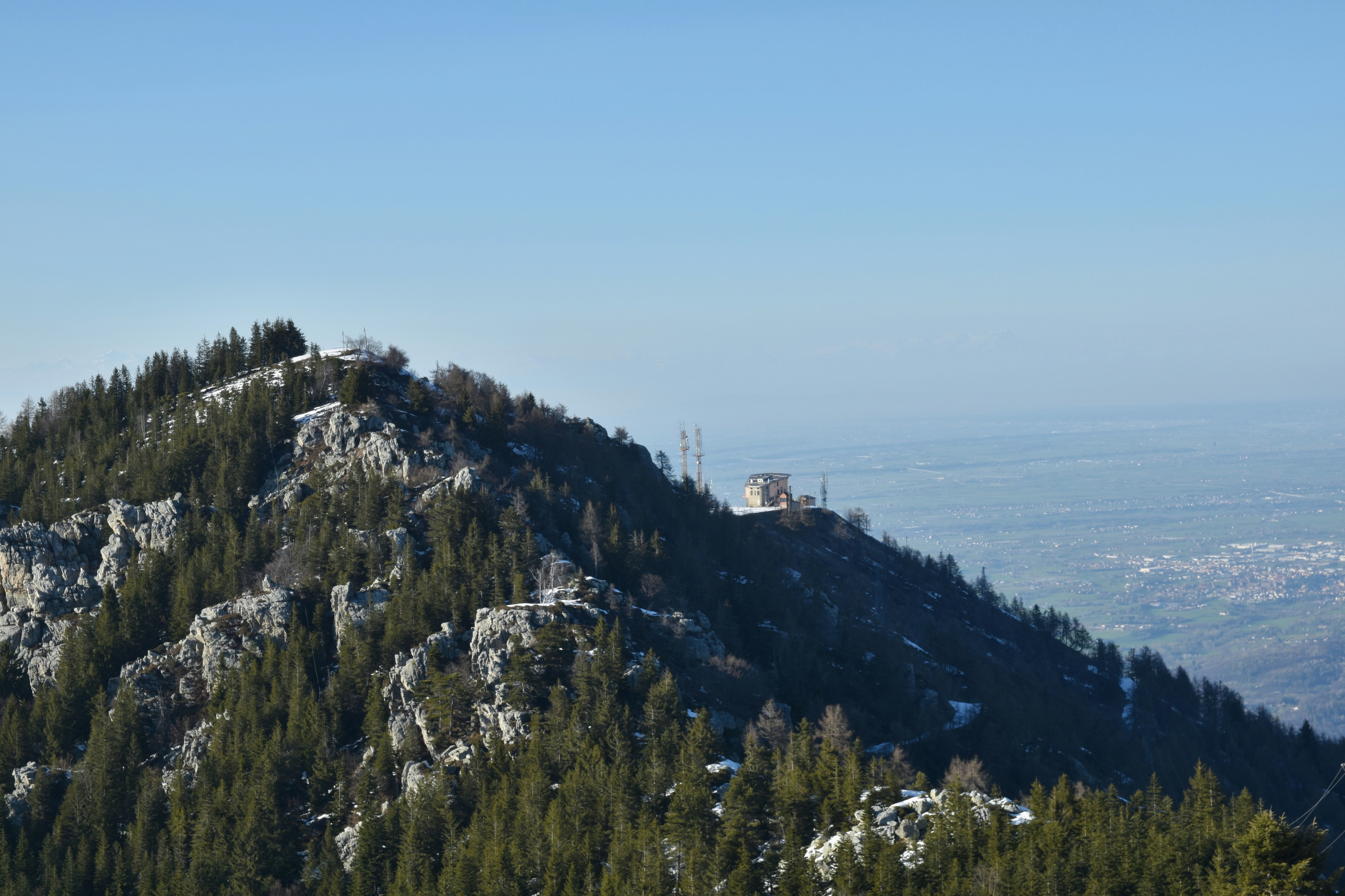 Pinnacle Shelter on a Pine-Crowned Ridge under a Clear Alpine Sky