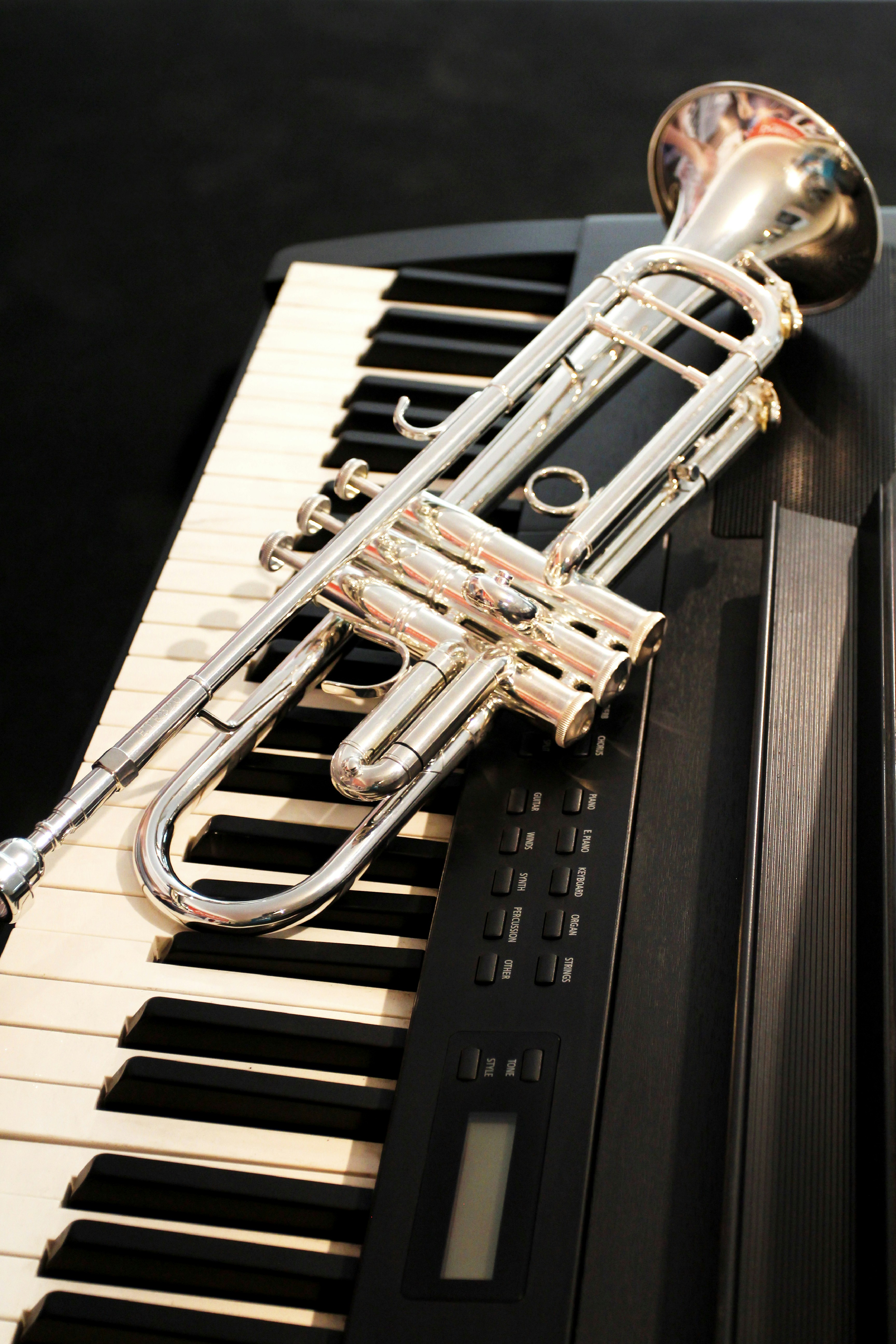 #trumpet #keyboard #music #instrument | A trumpet rests on a piano keyboard.