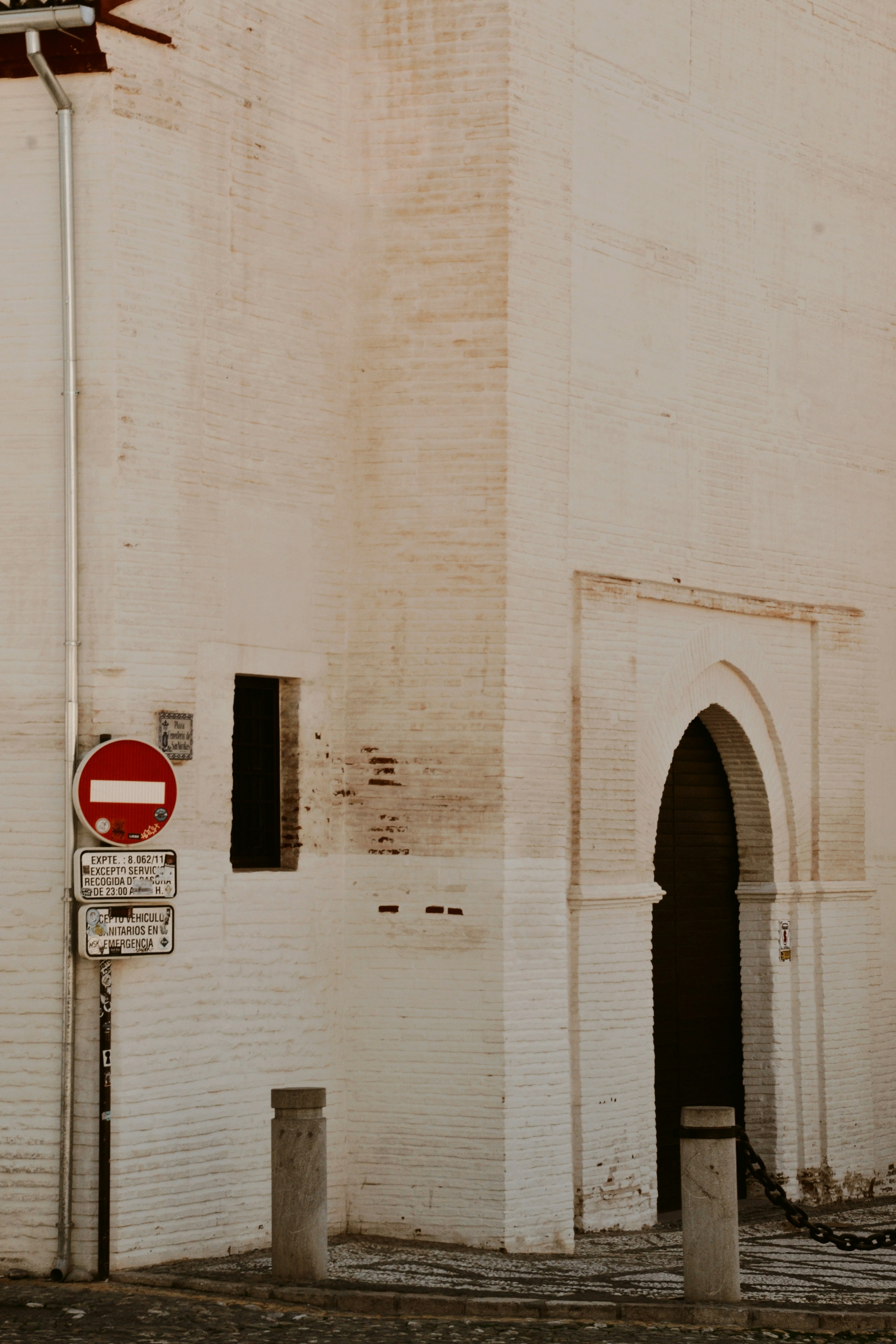 A brick building corner features signs and a doorway. photo – Free City ...