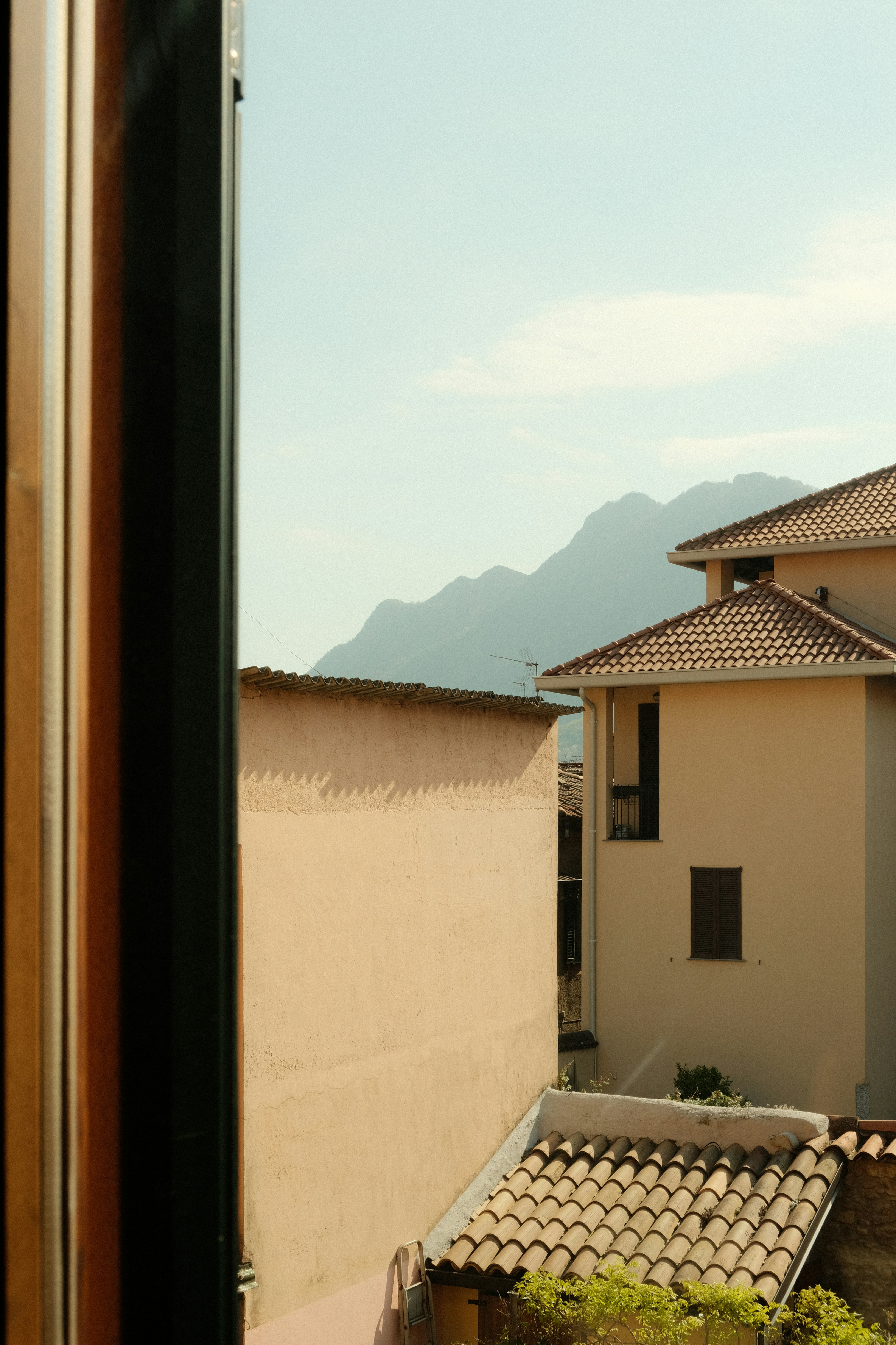 View from a window of buildings and mountains. photo – Free Italy Image ...