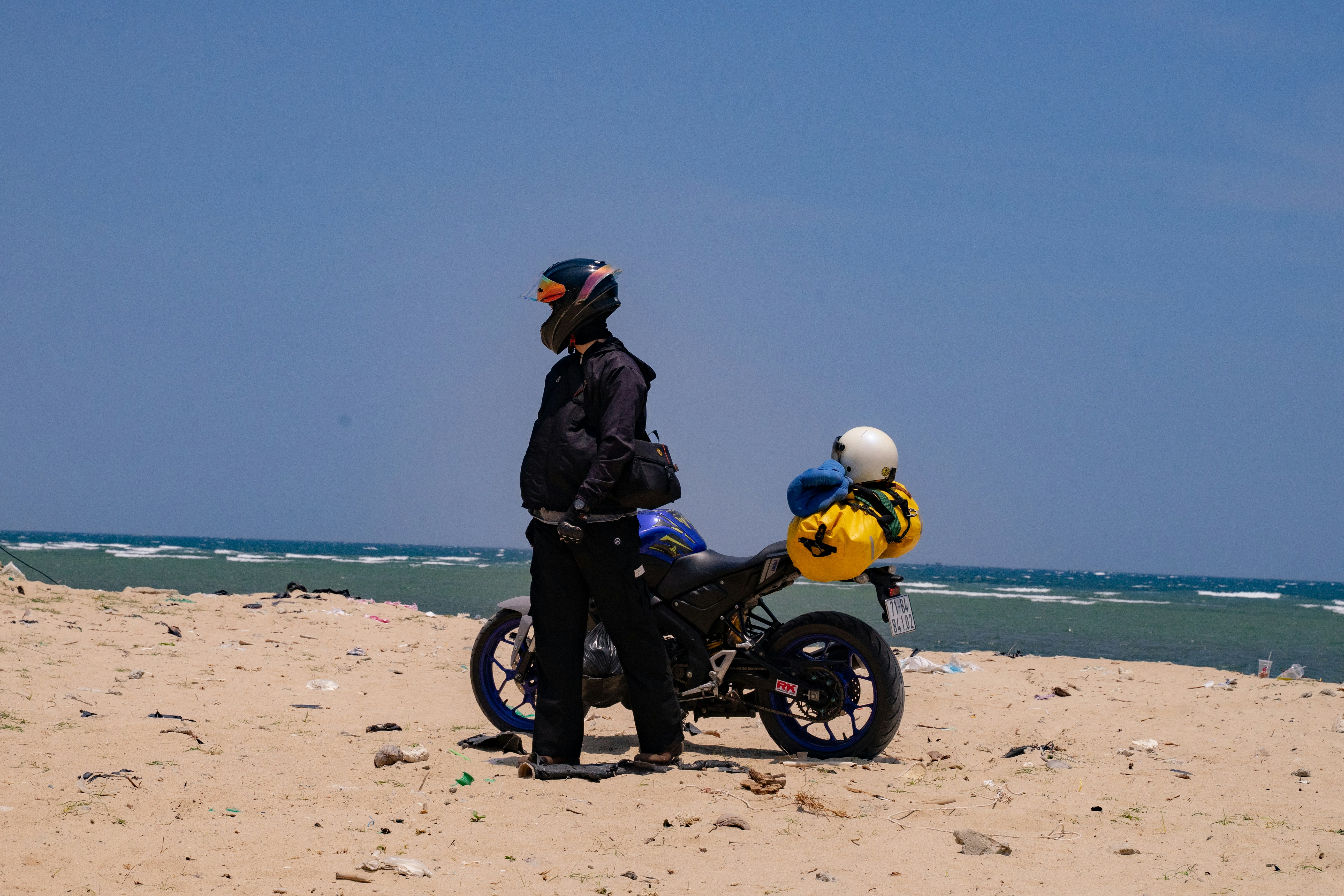 Coastal Pause: A Rider and Motorcycle at the Edge of the Sea