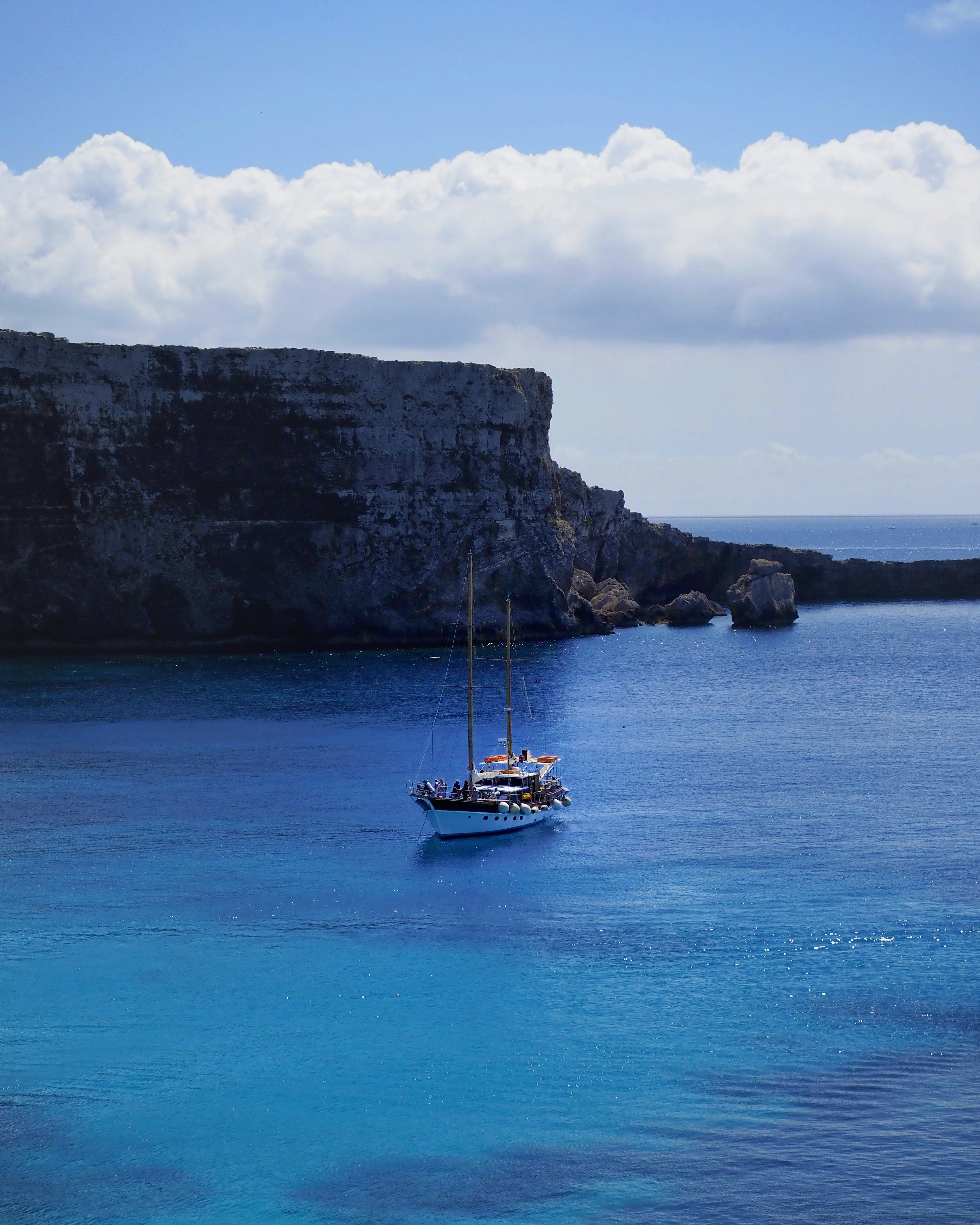 A large boat in a cove with clouds in the background