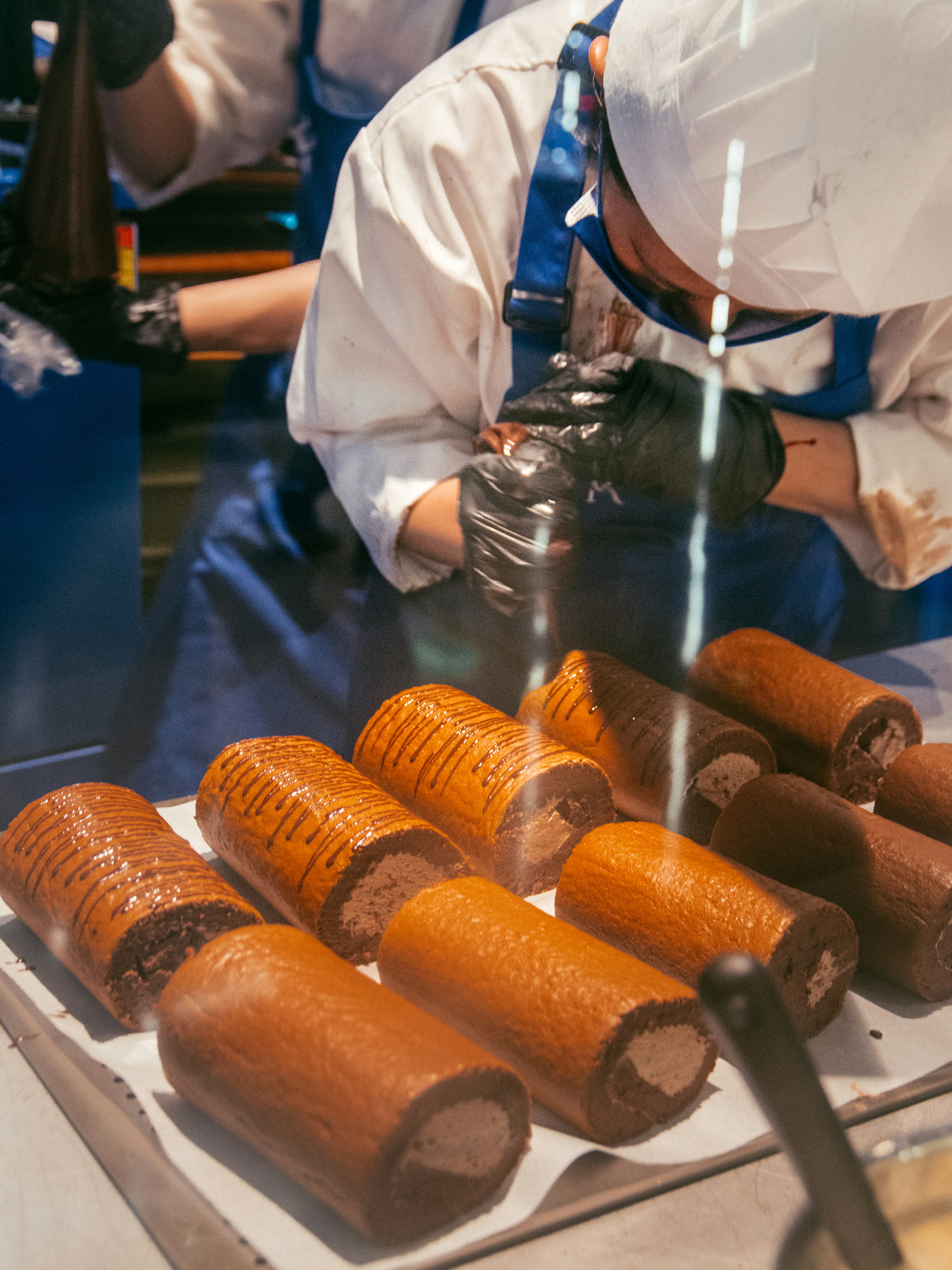 Baker rolls and prepares chocolate cake rolls.