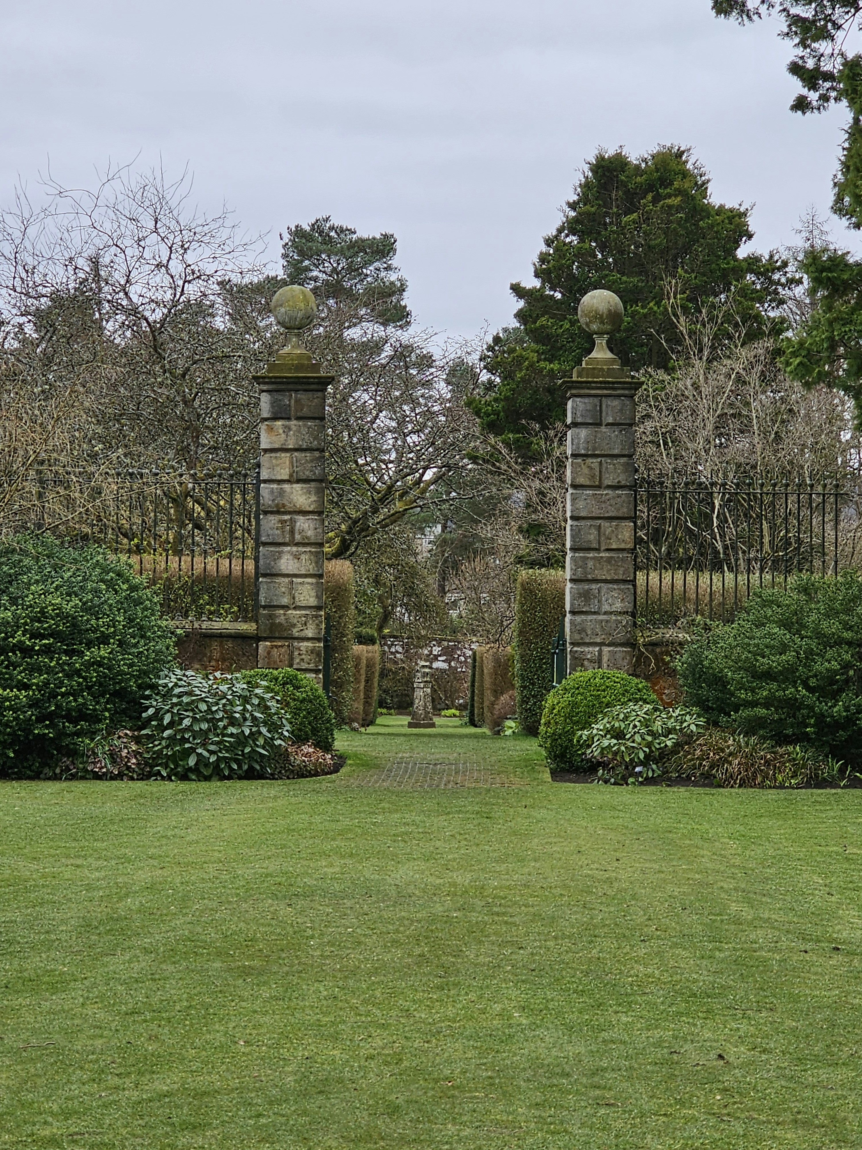 Stone gate posts frame a garden path. photo – Free Forest Image on Unsplash