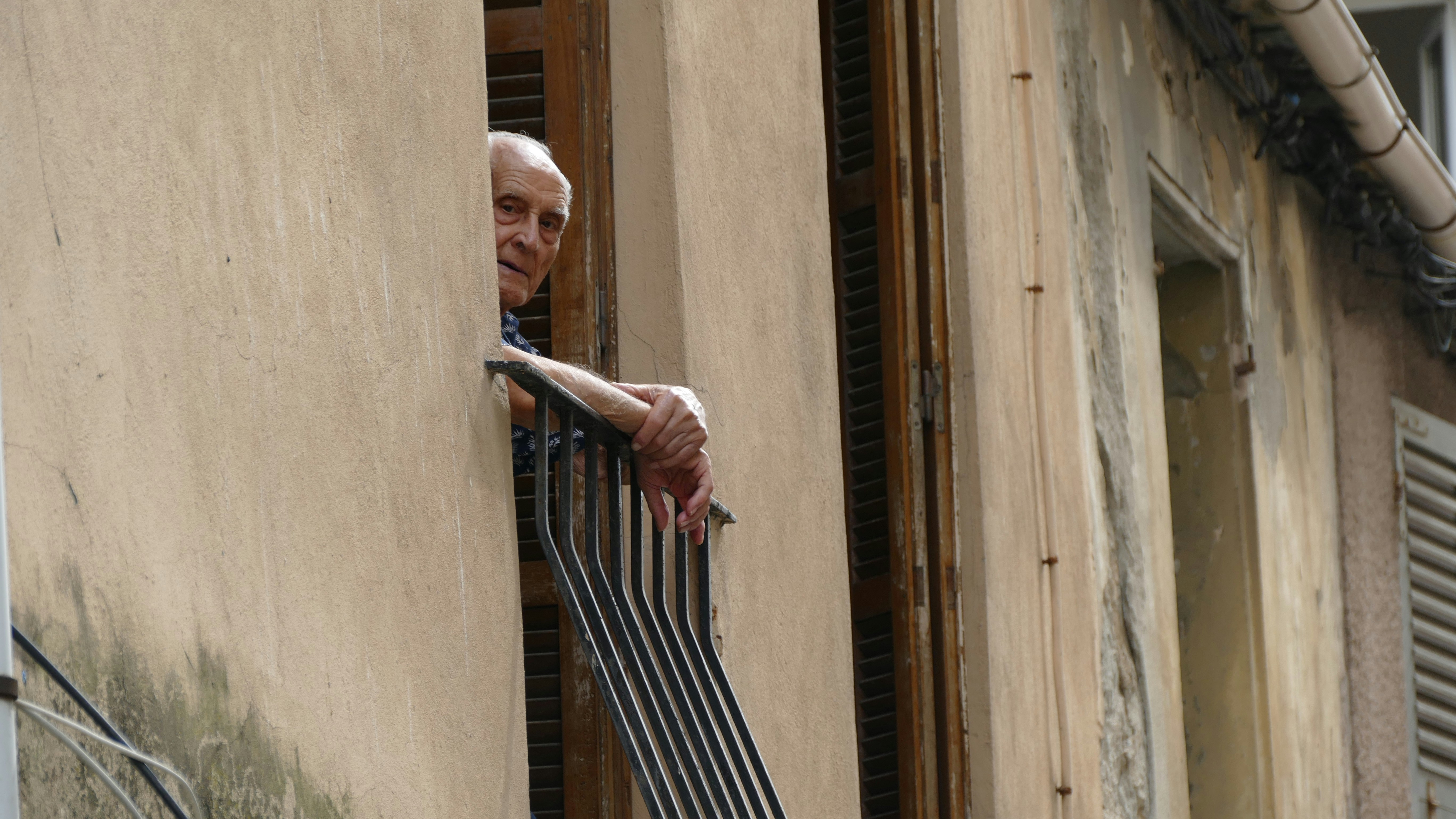 Balcony Observer: A Quiet Gaze from a Weathered Facade