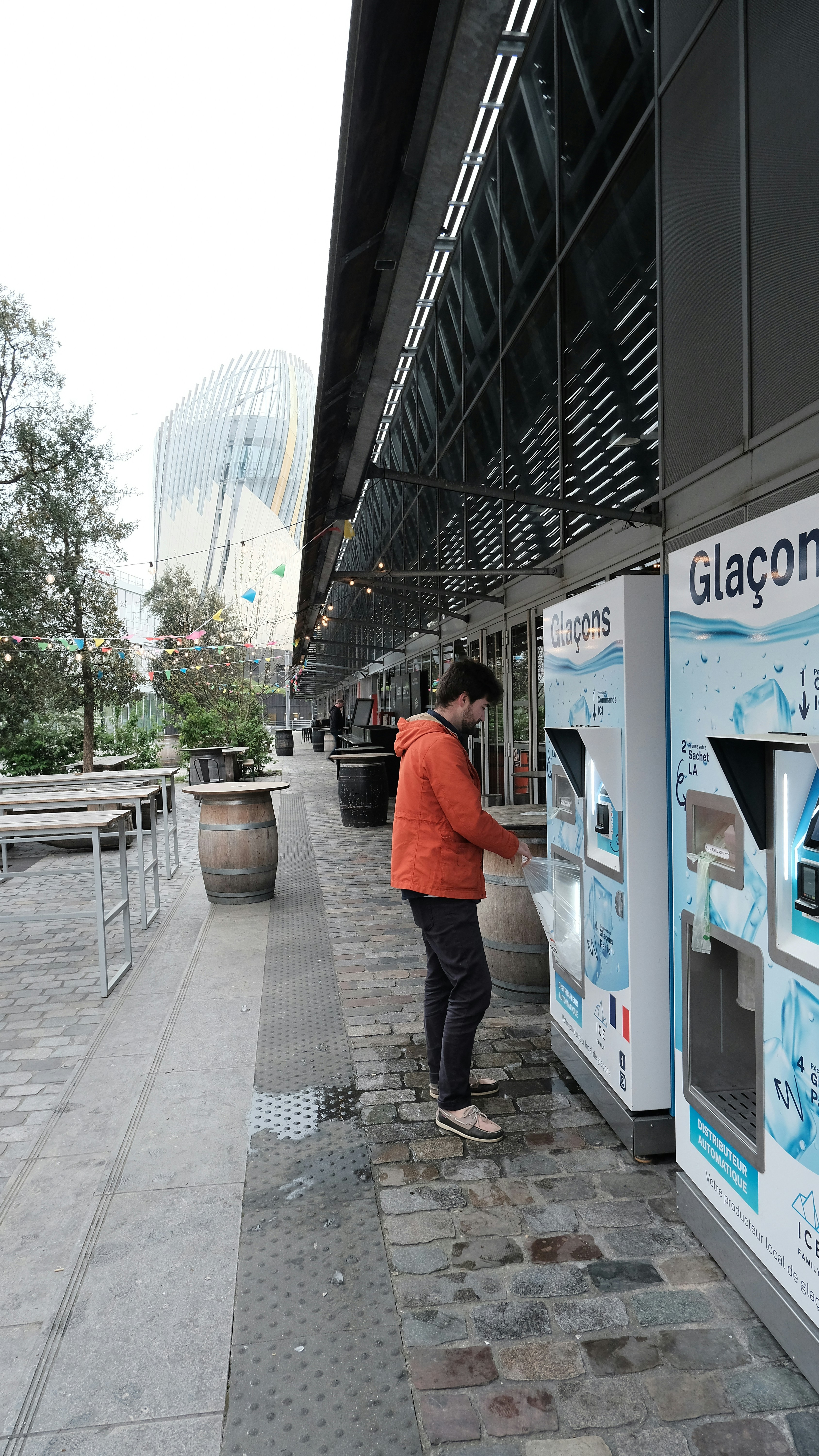 A man refills a bottle at a water dispenser. photo – Free Ice Image on ...