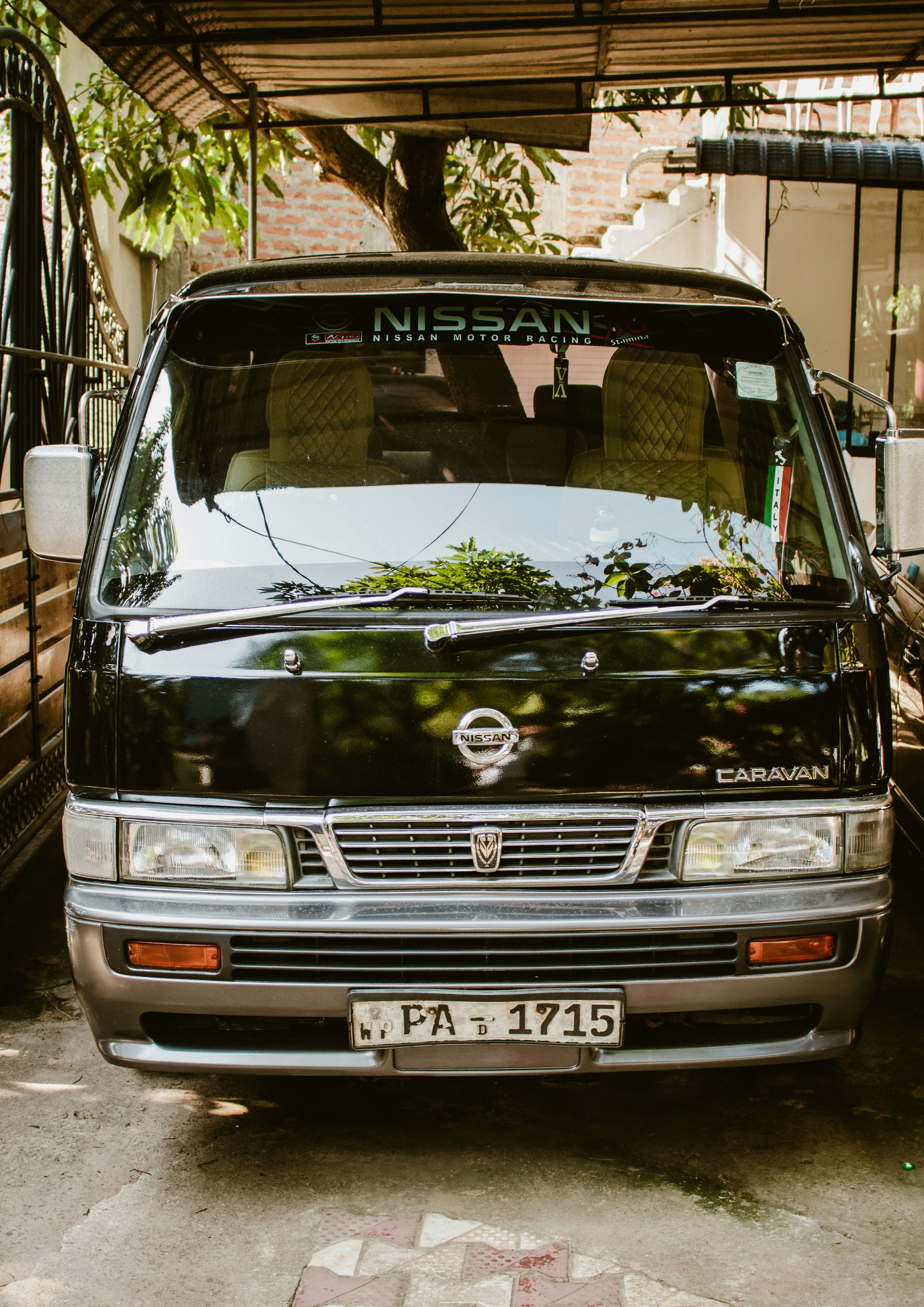 A nissan caravan is parked under a shelter. photo – Free Car Image on ...