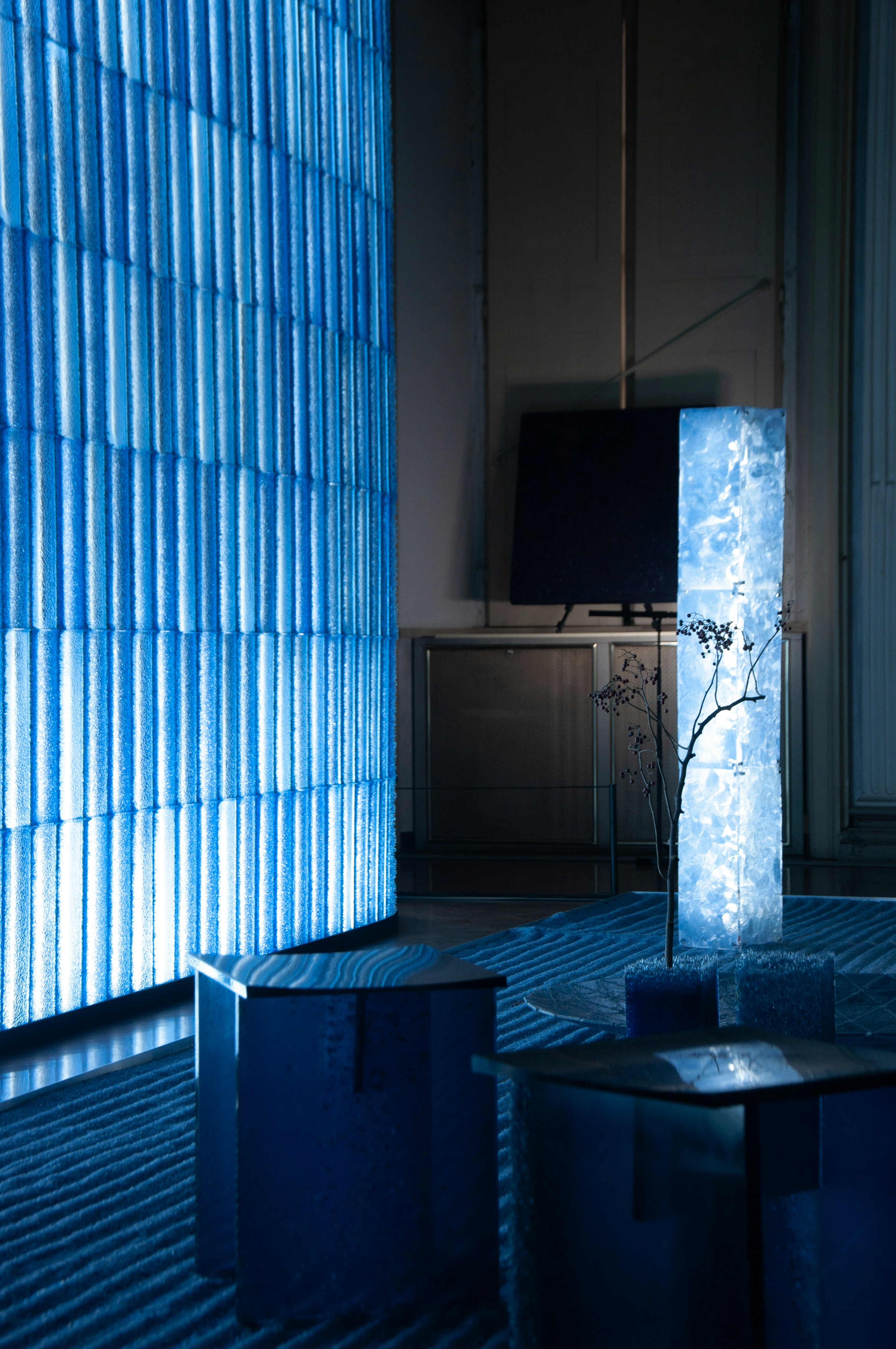 Blue-lit art installation featuring a column and wall. photo – Free Art ...
