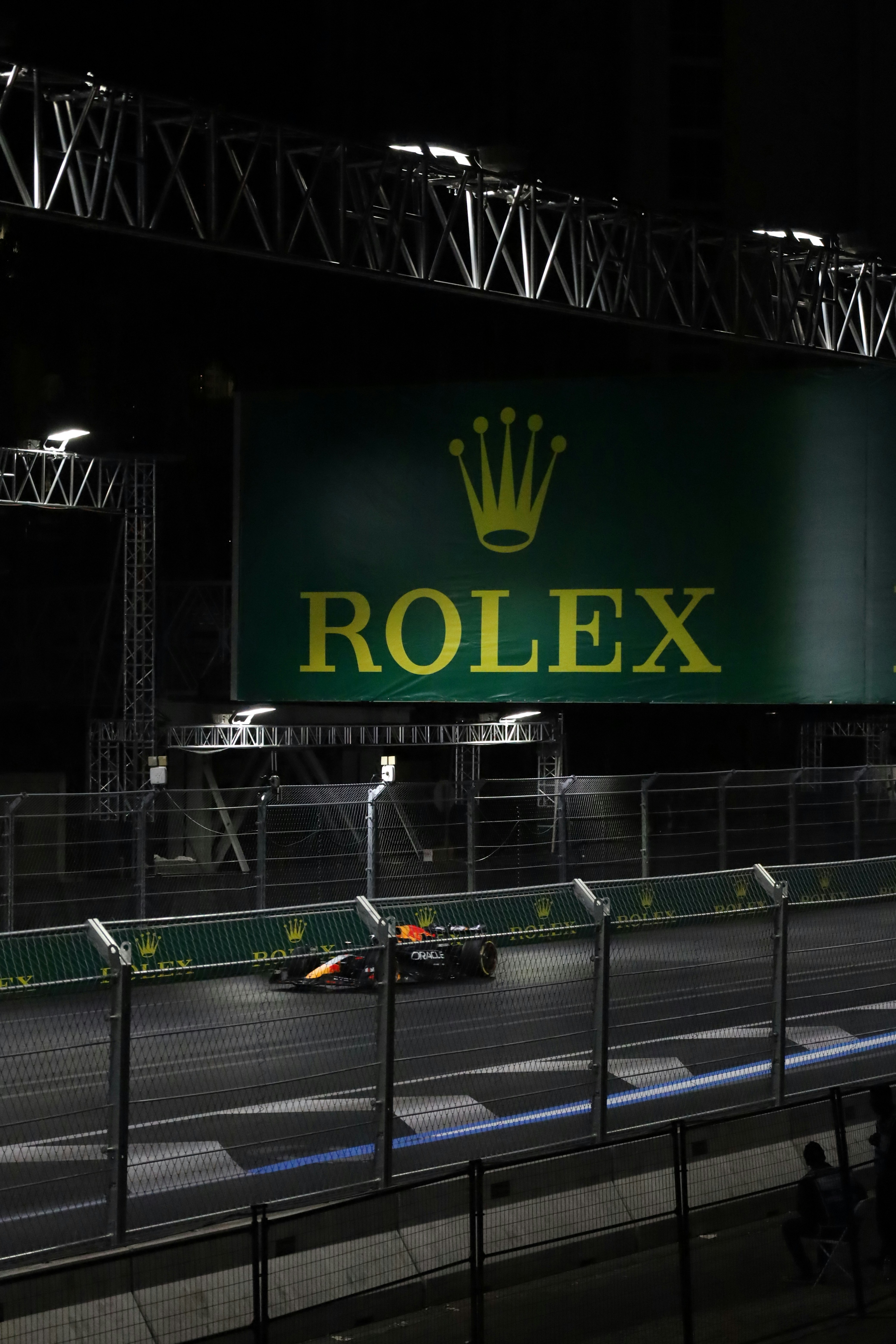 A race car speeds past a rolex advertisement. photo – Free Car Image on ...