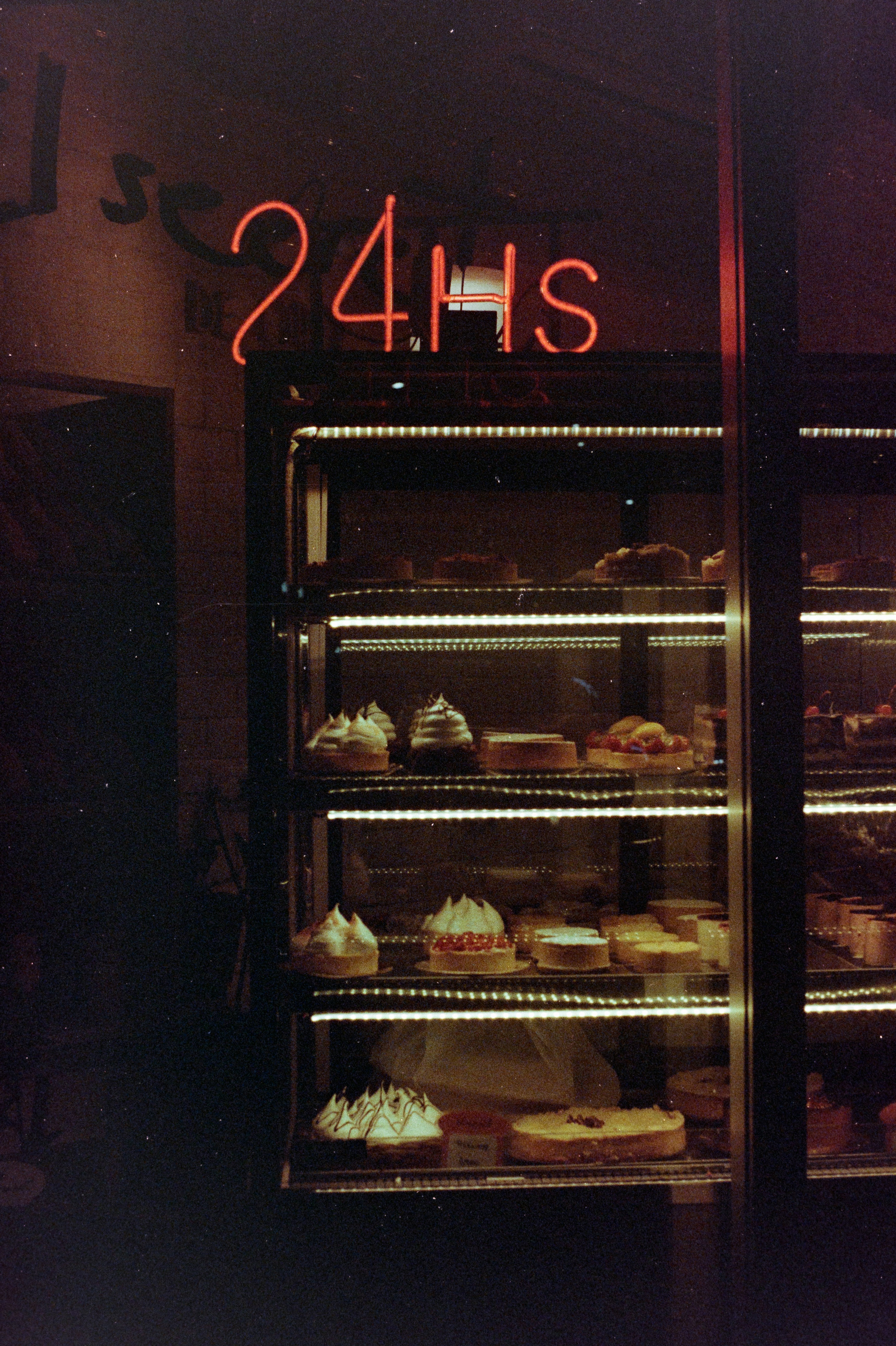 Midnight Cakes Under Neon Glow: A Quiet Bakery Window