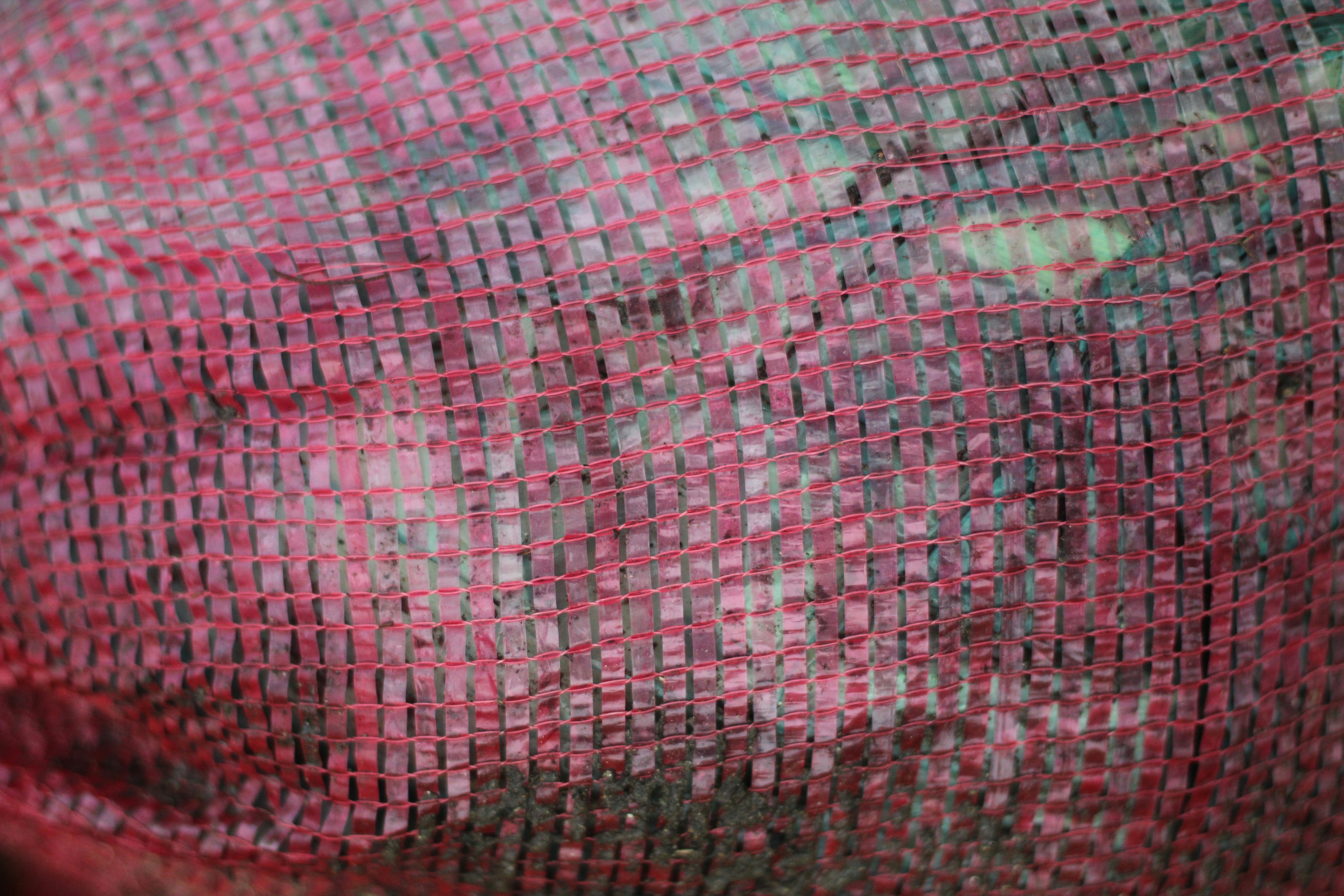 Red netting reveals a blurry view. photo – Free Texture Image on Unsplash