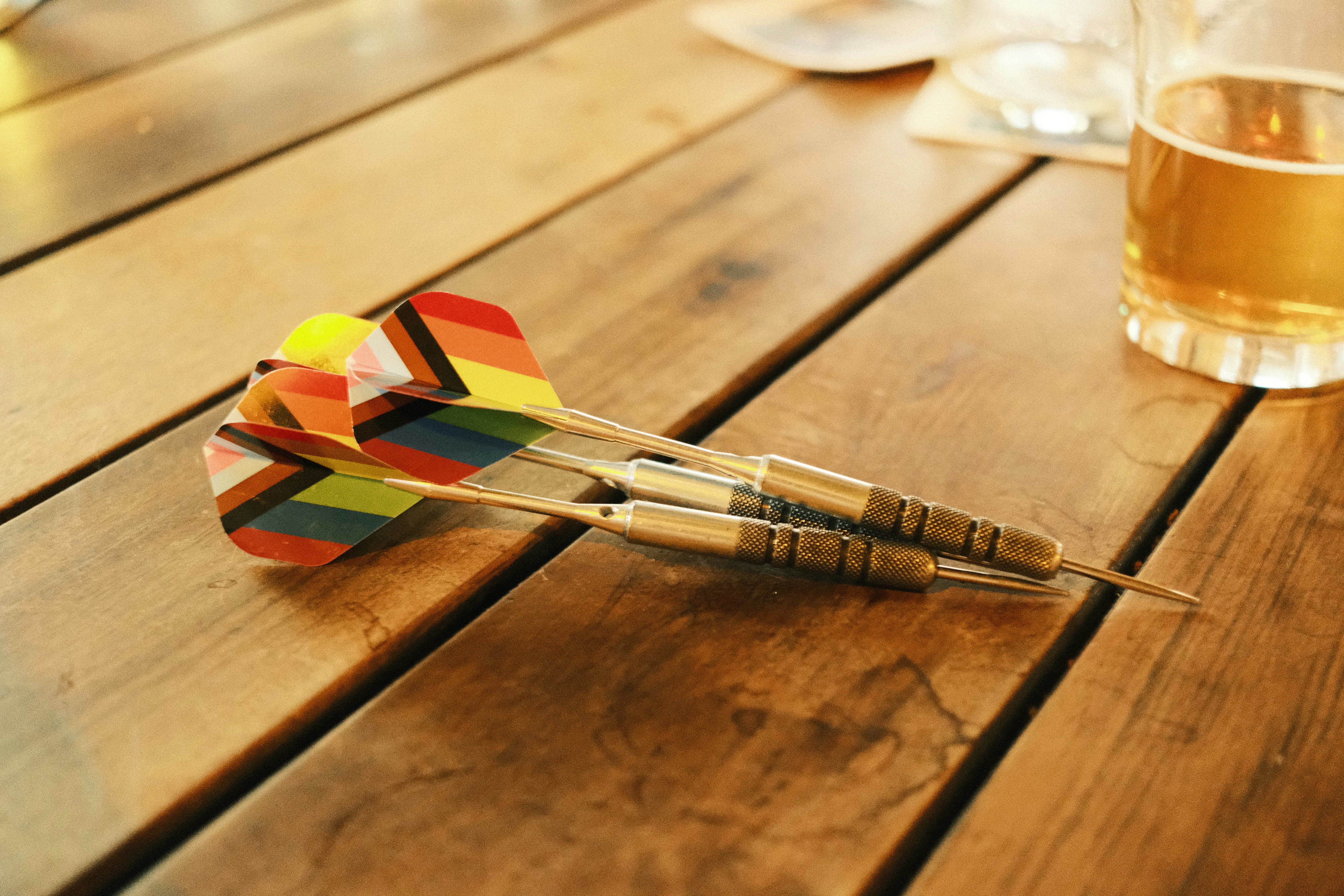 Colorful Darts Resting on Rustic Wood