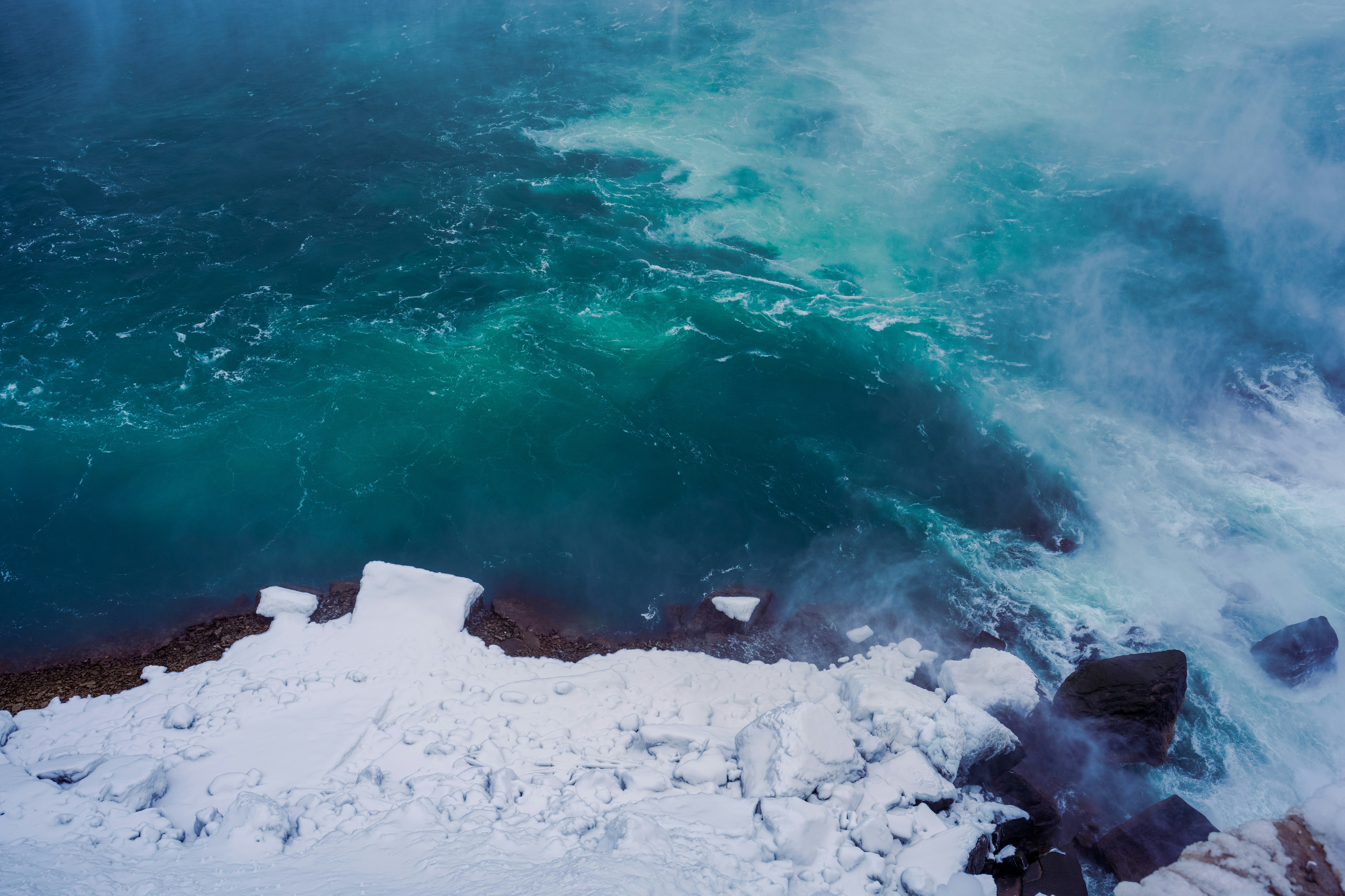 Frigid shoreline empties into turquoise depths