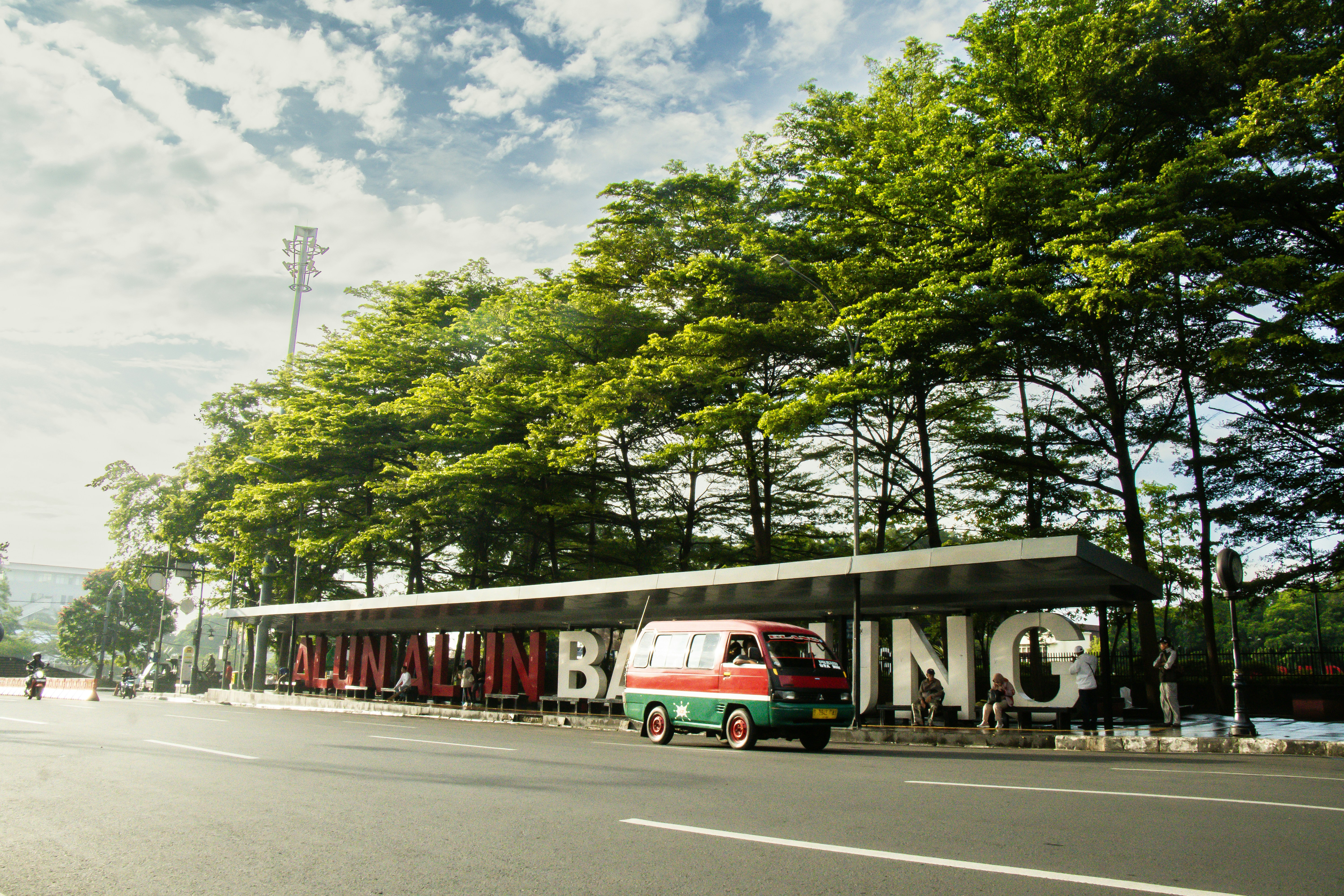 Bus Stop Mosaic: A Retro Van and Greenery at an Urban Entrance