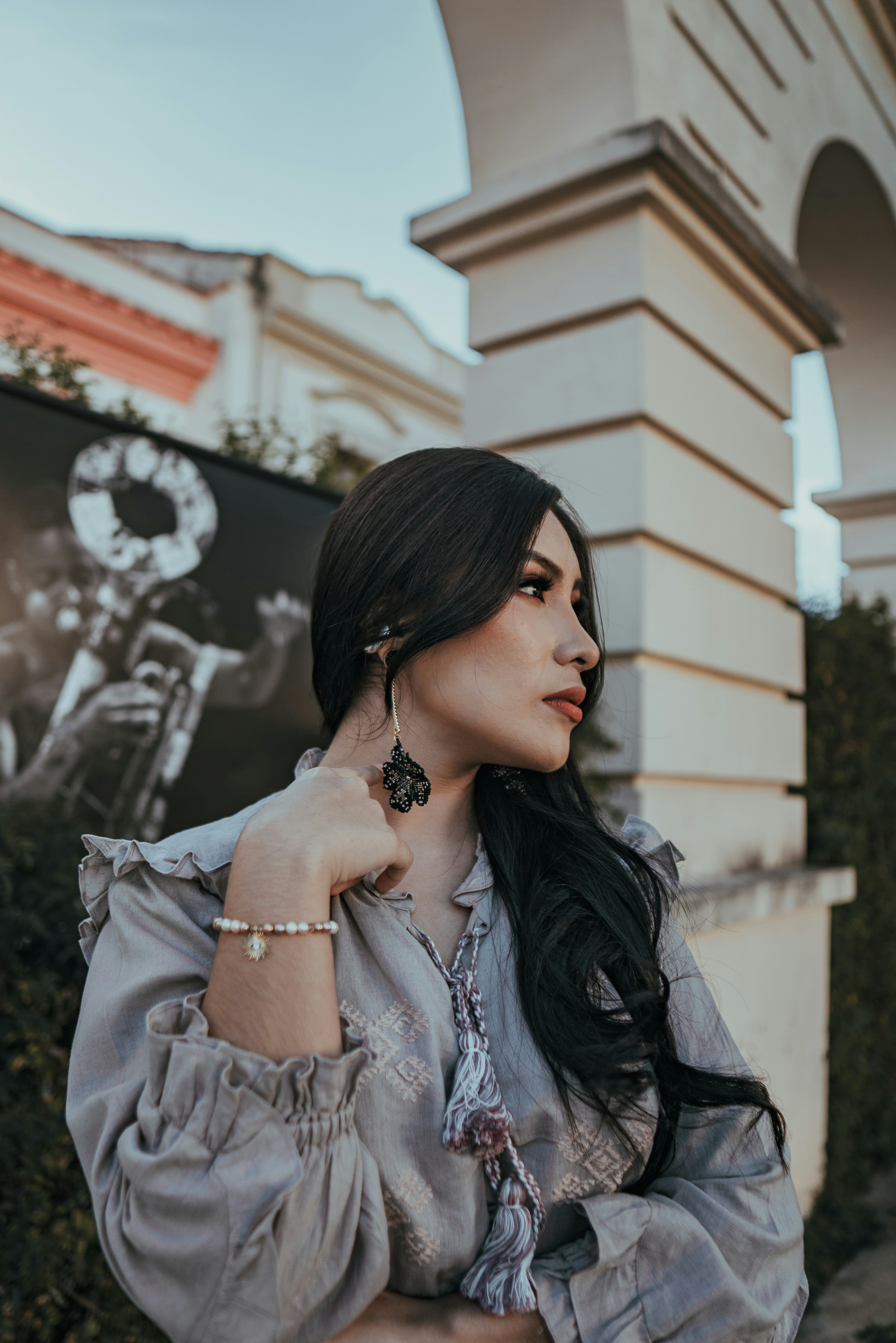  side-lit portrait of a woman in an architectural courtyard with a decorative black earring