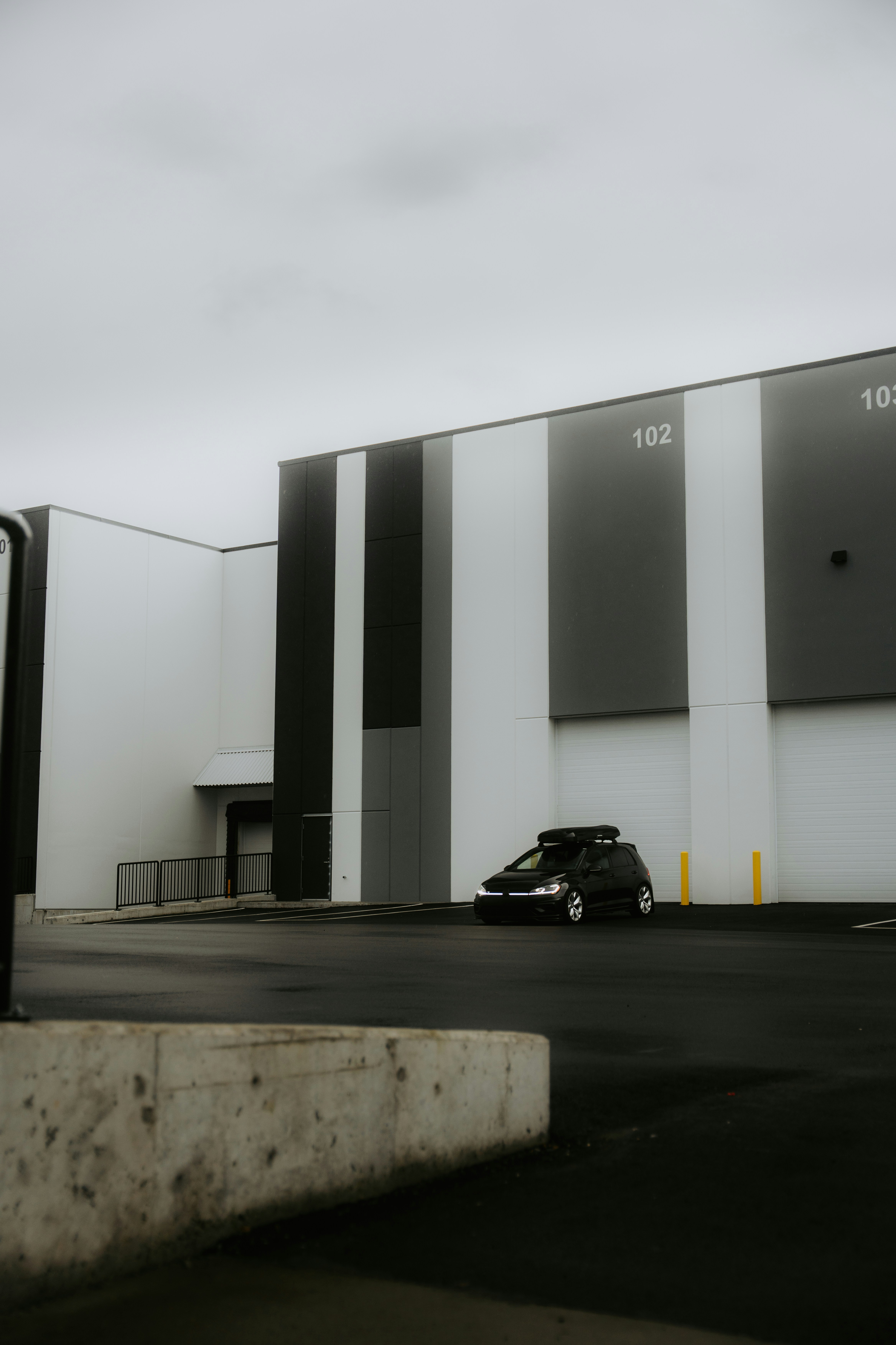 A car is parked in front of a large building. photo – Free Car Image on ...