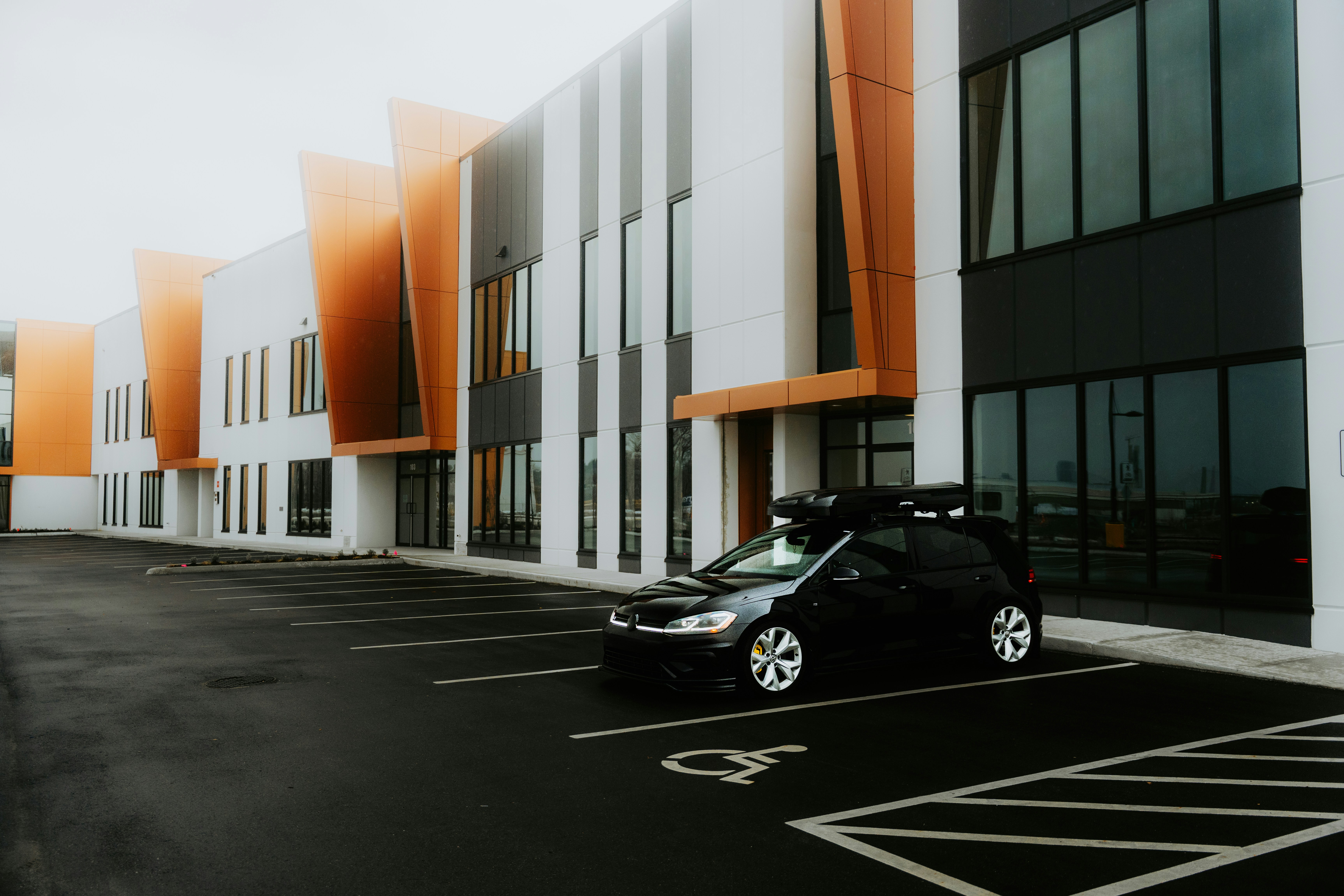 Sunlit Facade and Parked Compact in a Modern Office Park