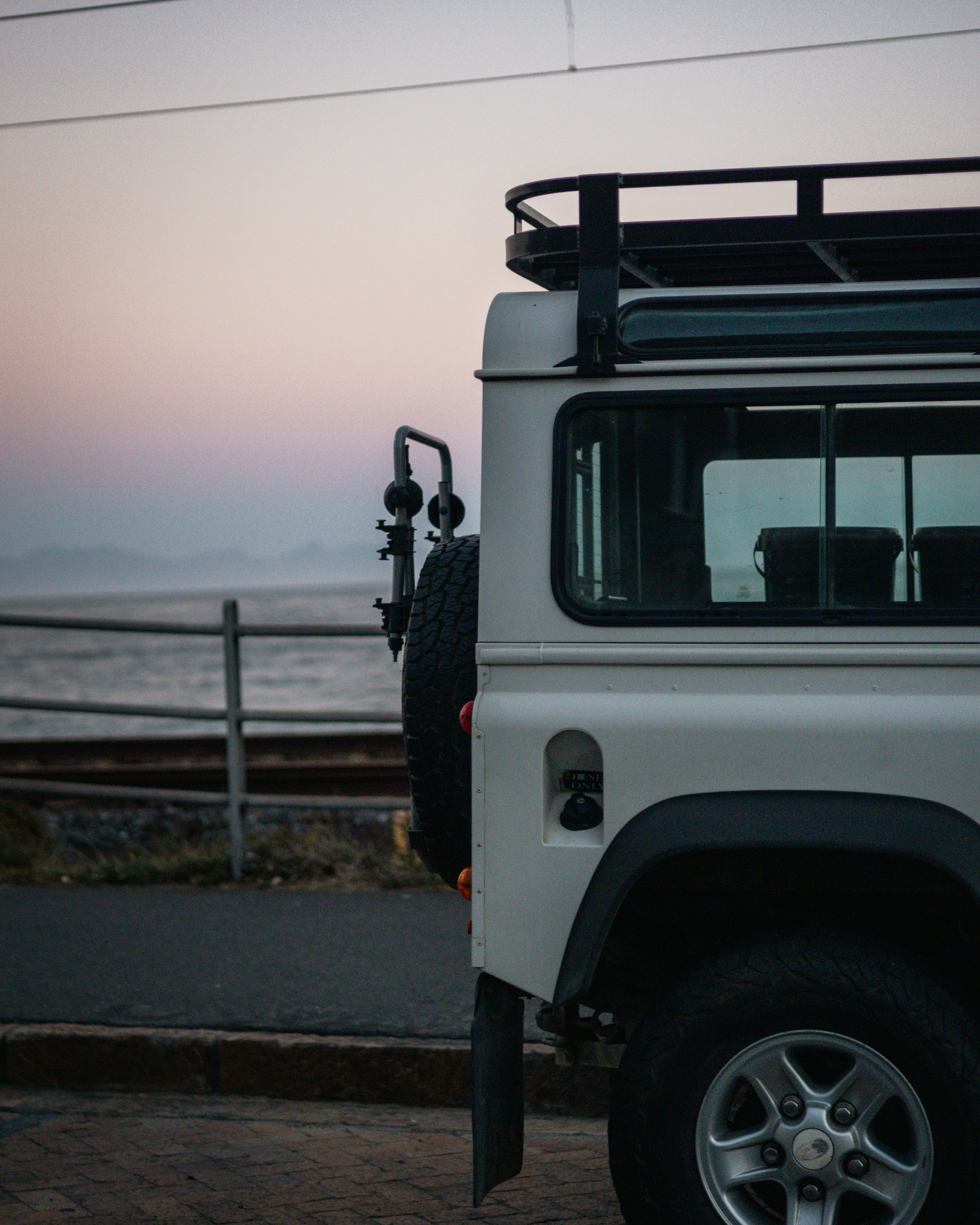 Land Rover Defender with a False Bay sunset in the background.