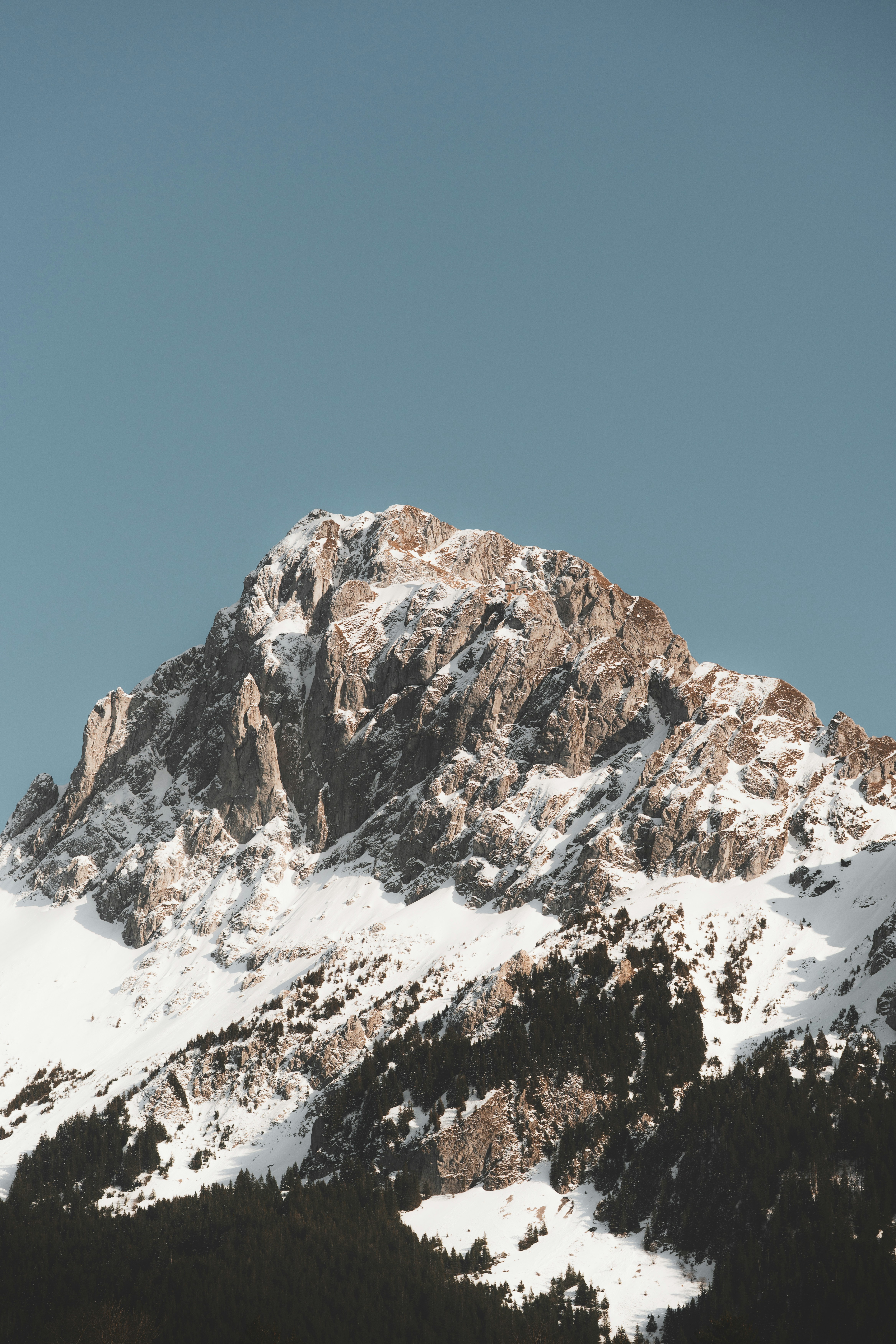 Snow-covered mountain peak under a clear blue sky.